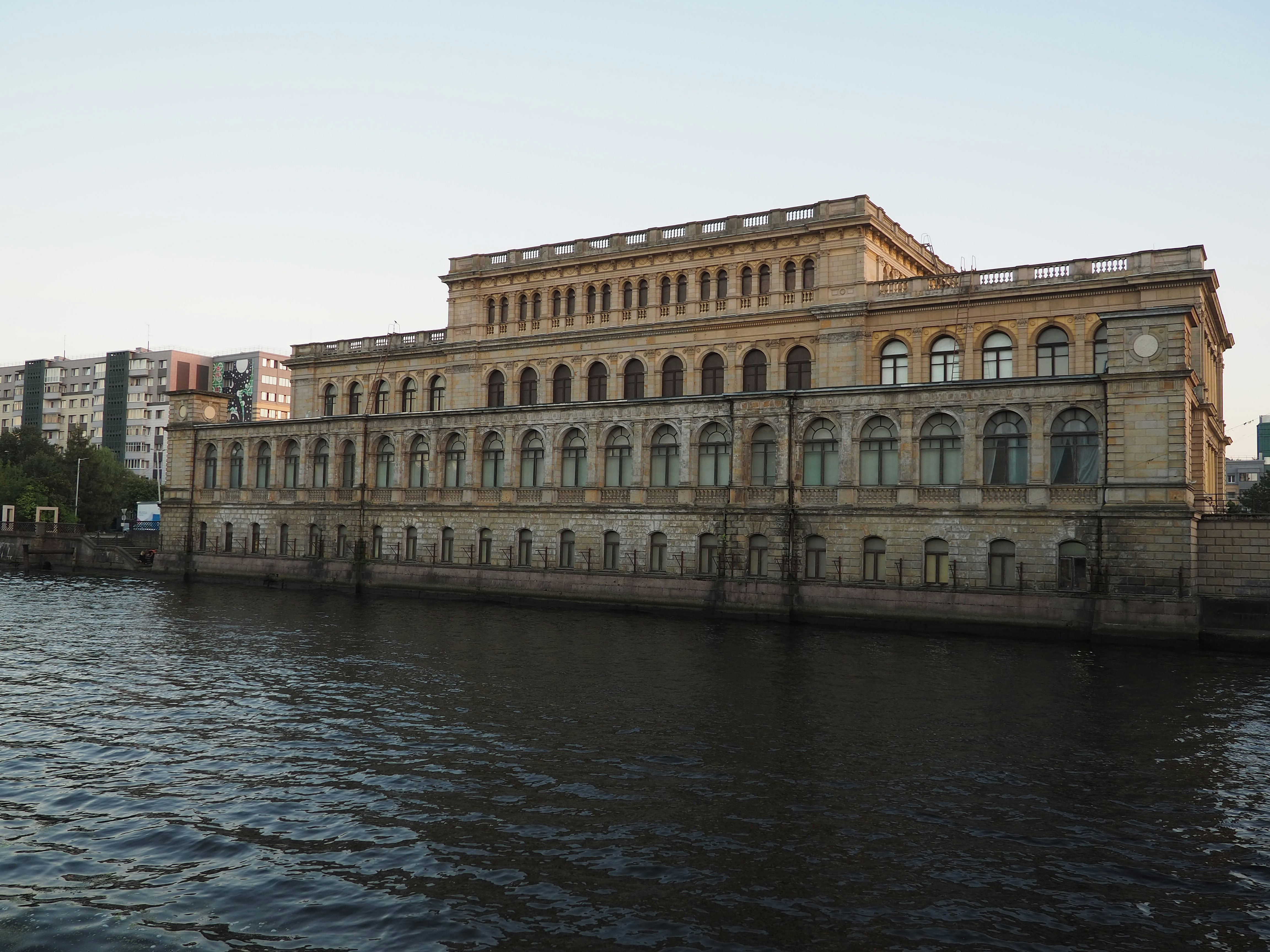 A large building sitting on the side of a river photo – Free Building ...