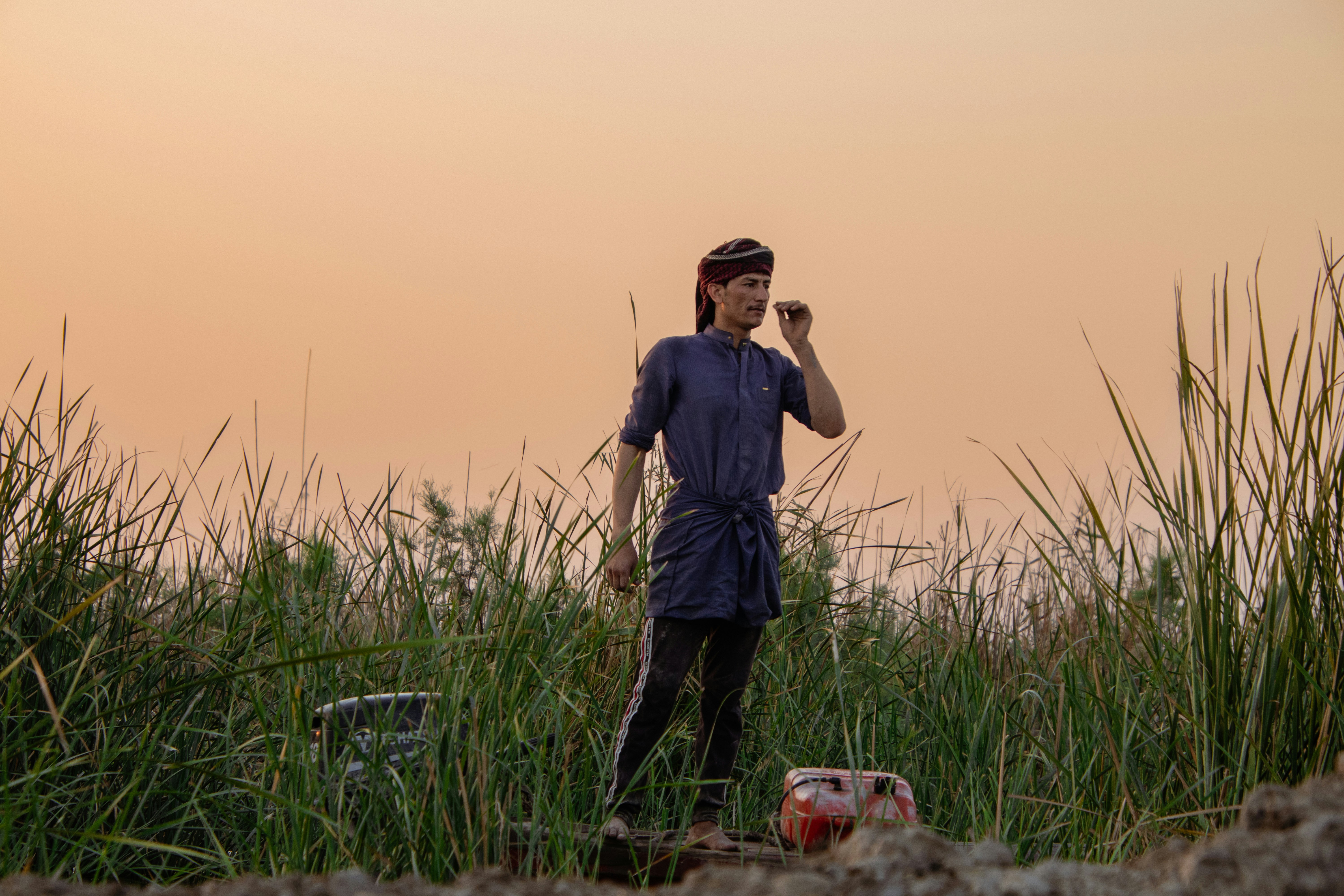 A man standing in a field of tall grass photo – Free Iraq Image on Unsplash