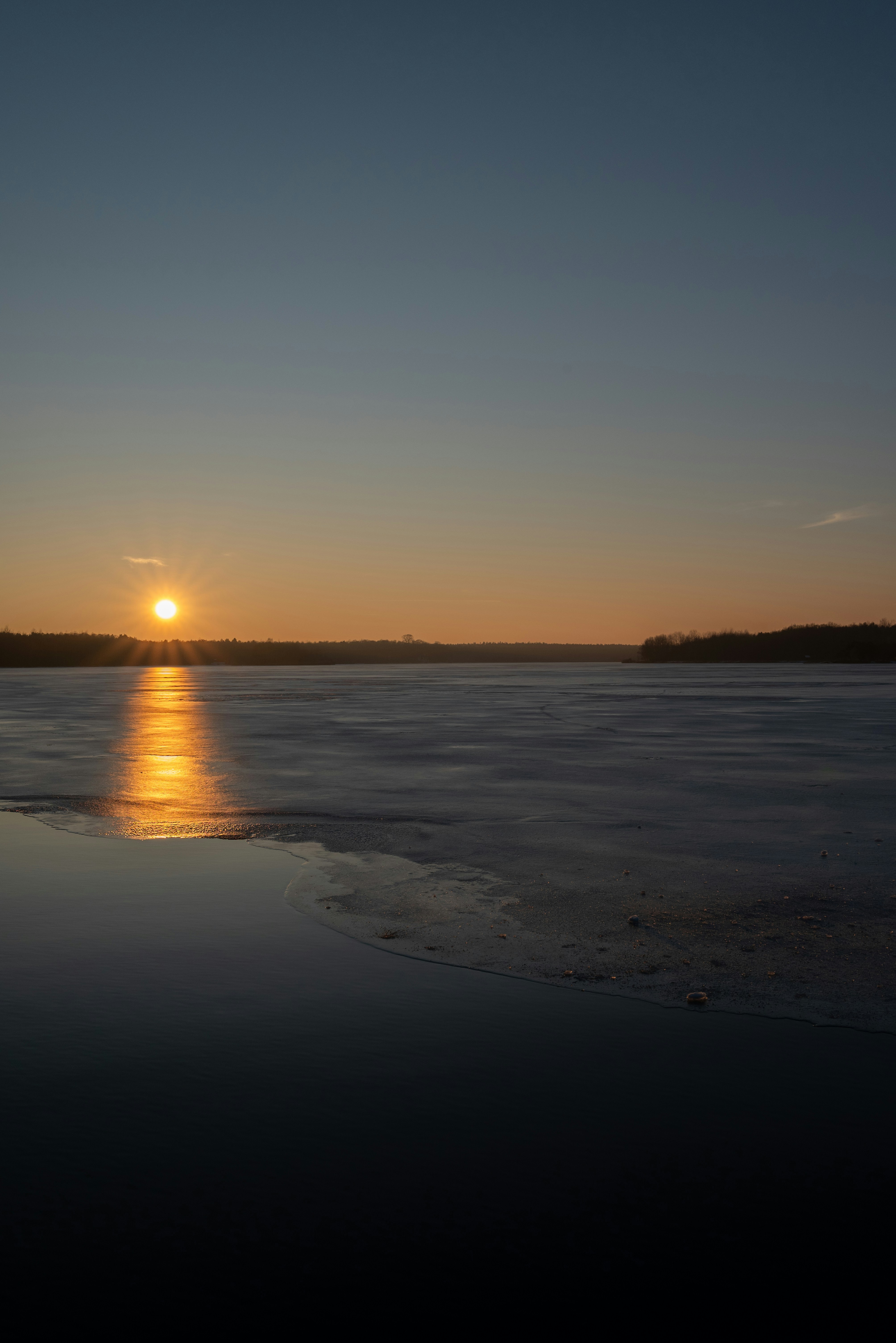 The sun is setting over a body of water photo – Free Paprocany Image on ...