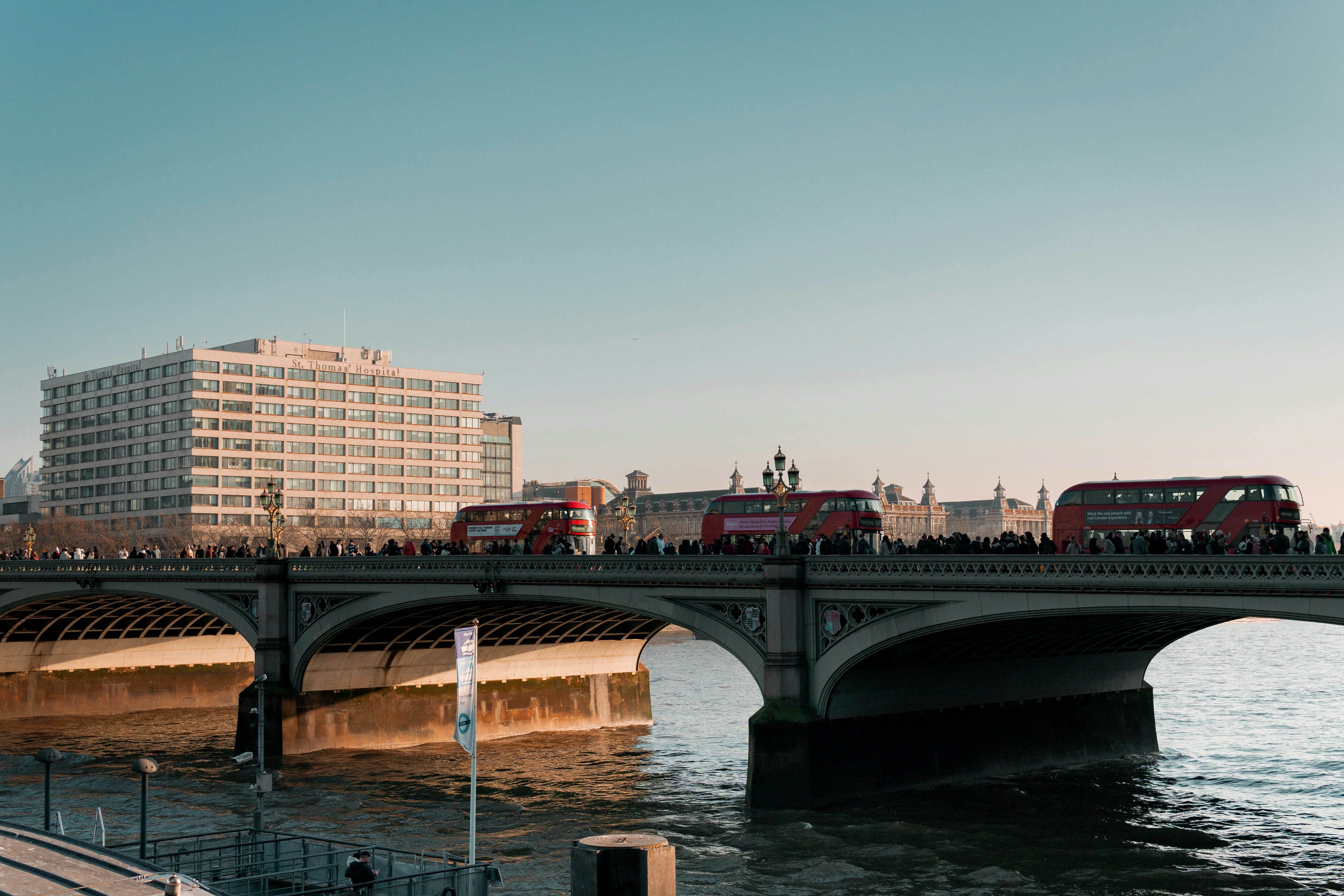 A bridge over a body of water with buildings in the background
