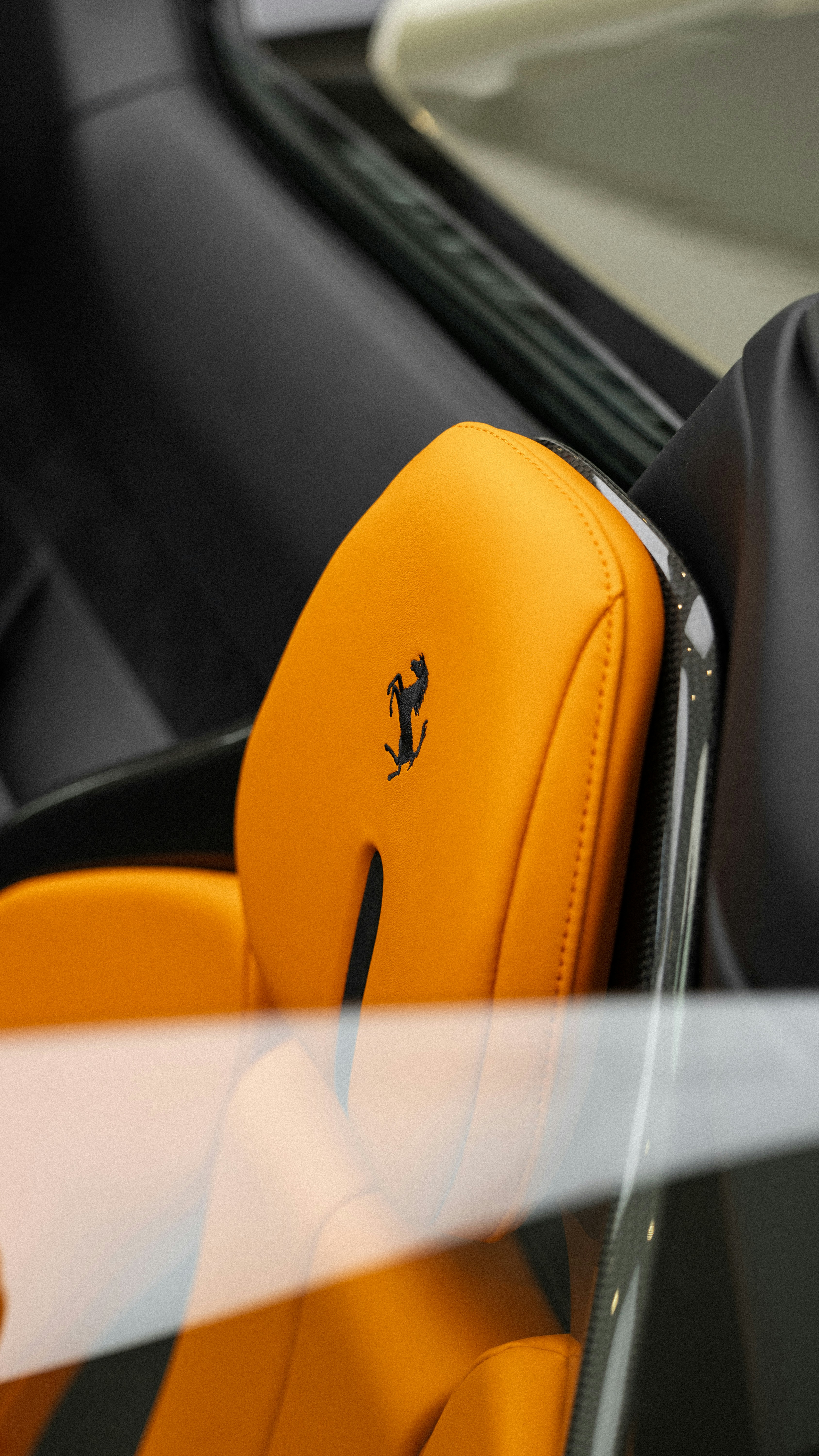 Orange Ferrari Seat Close-Up: A Glimpse of Luxury Craftsmanship