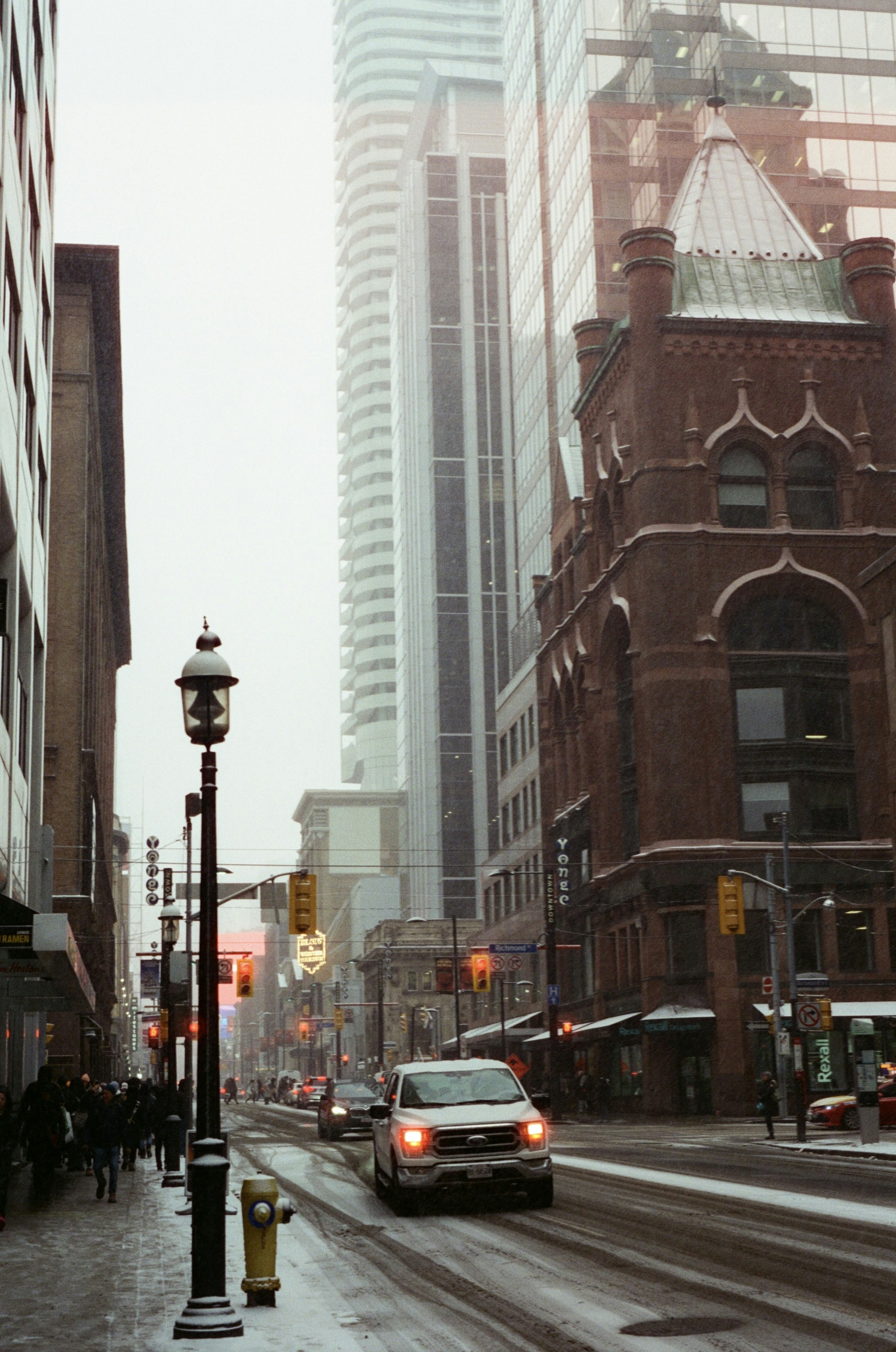 A car driving down a street next to tall buildings