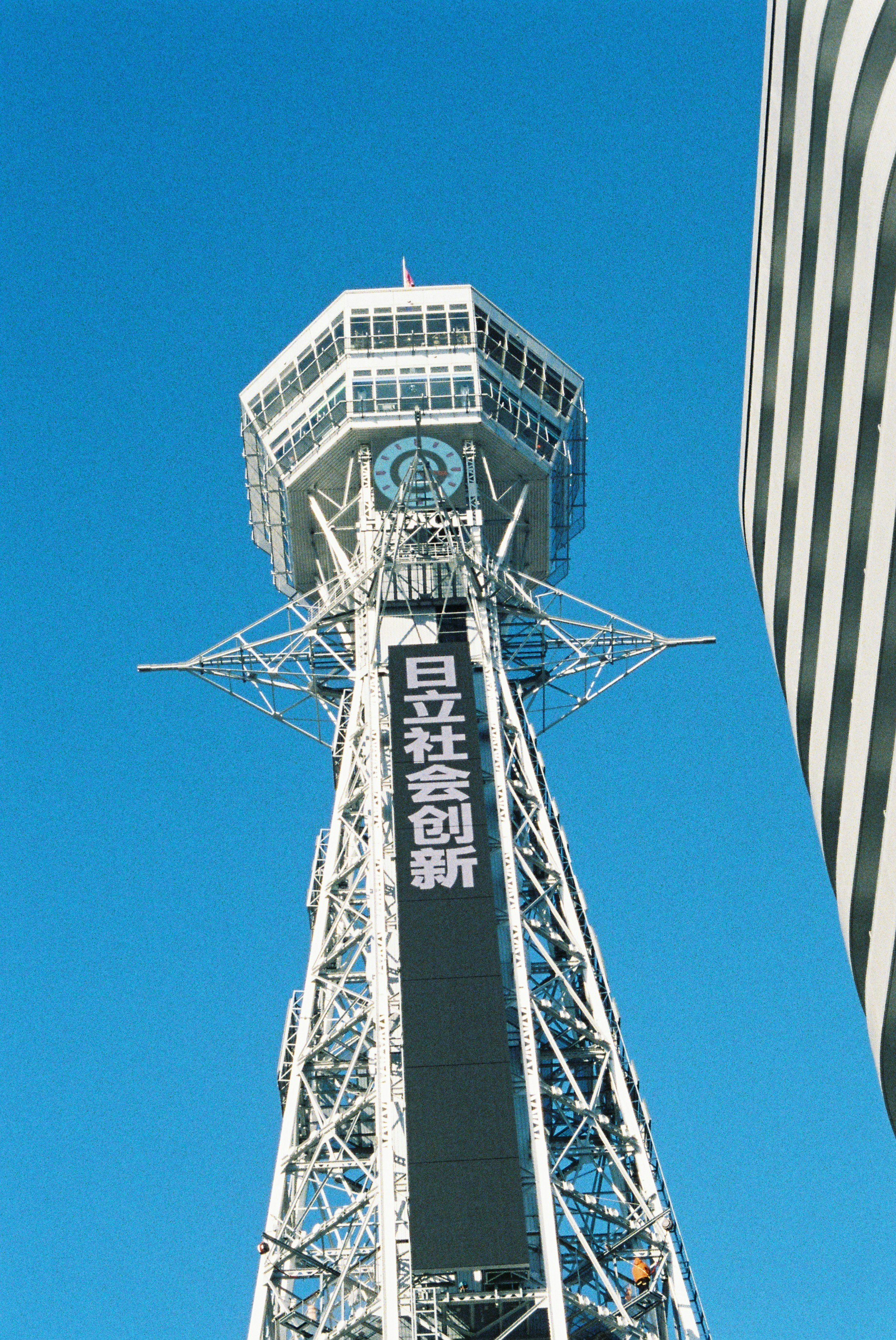 Skyframe Tower: A Lattice Spire Rising Beside a Striped Glass Edifice