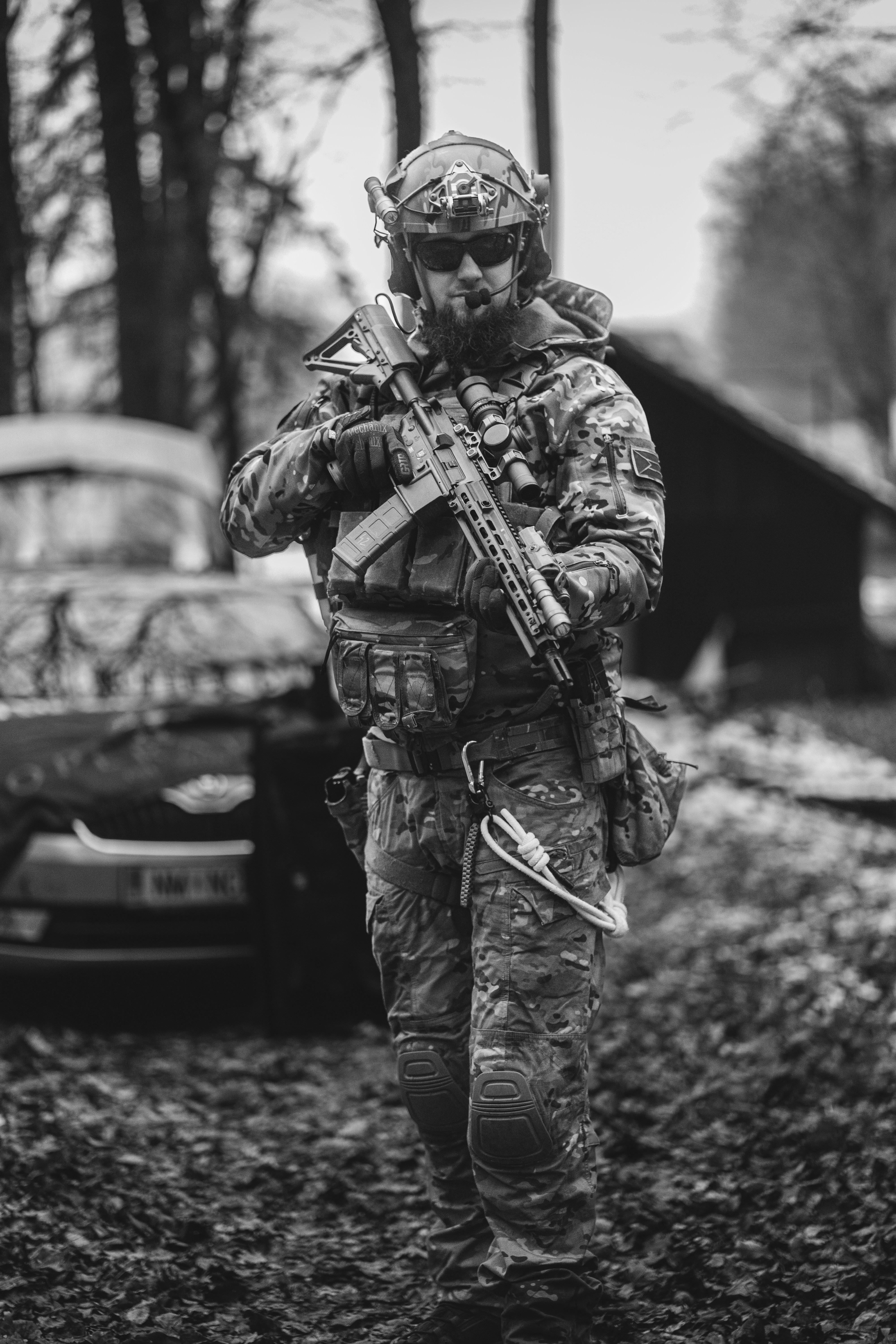 Monochrome Sentinel: A fully geared operator stands ready in a forested backdrop