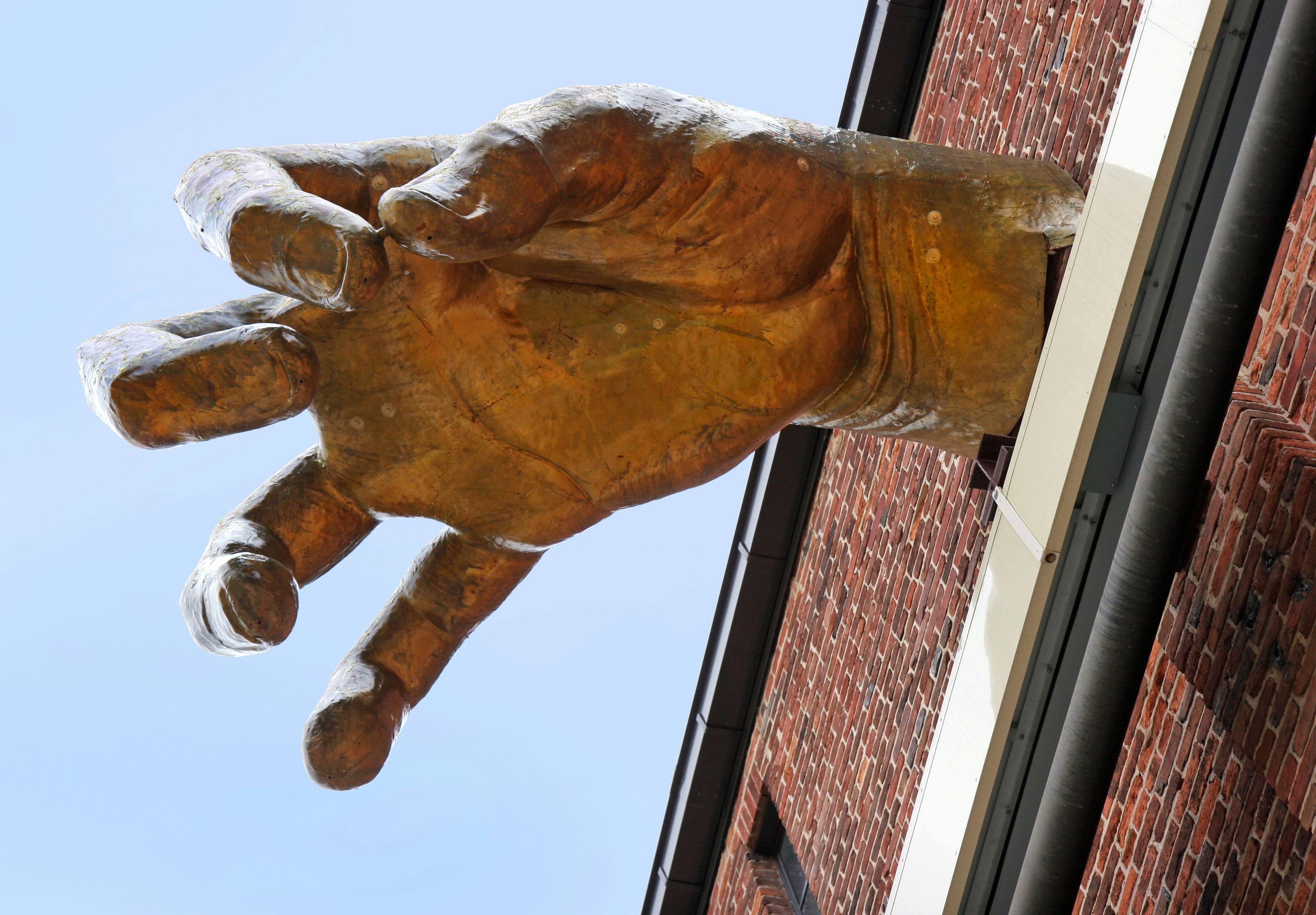 A statue of a hand reaching out of a window photo – Free Art Image on ...