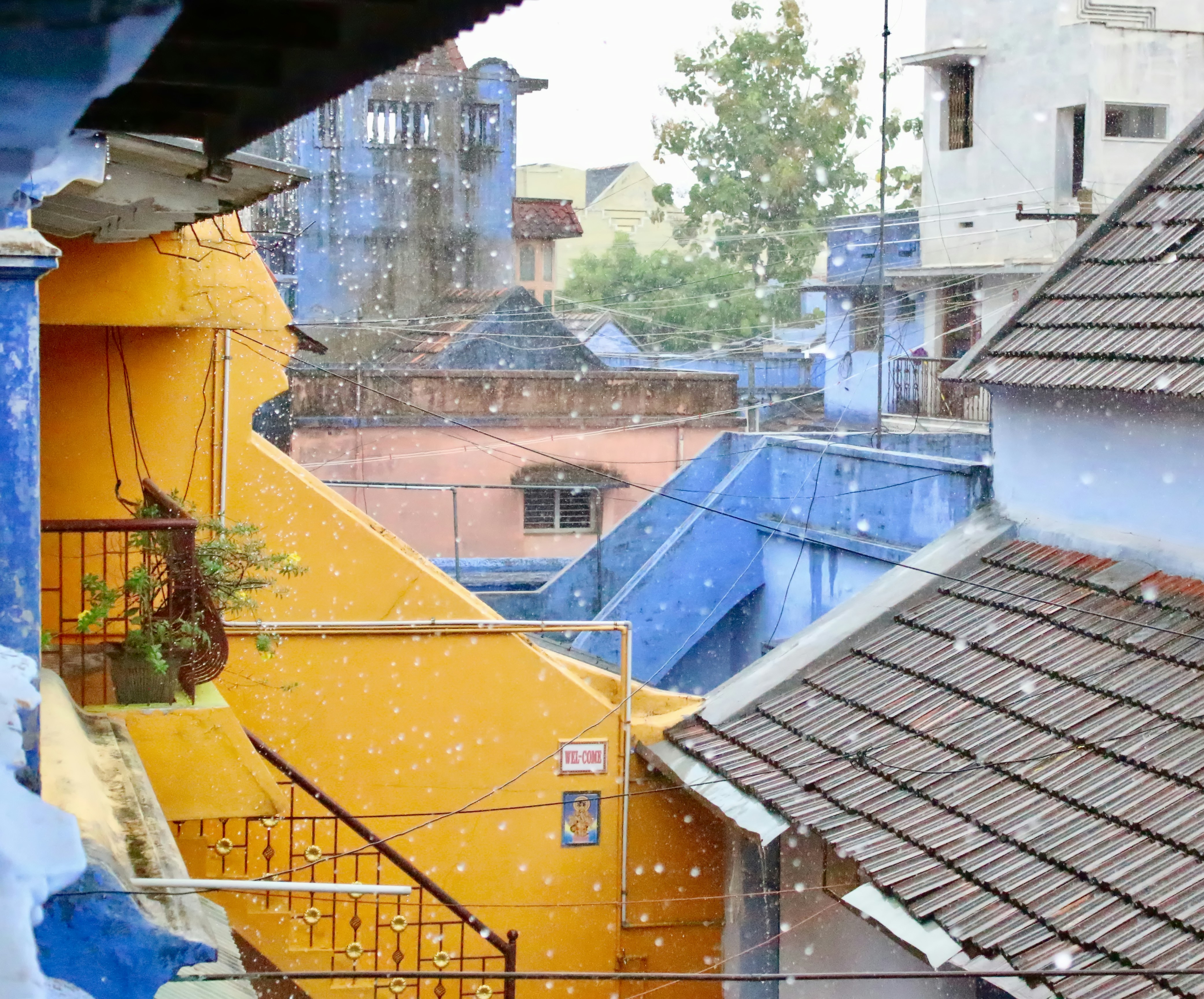 Rain-Splashed Palette: Yellow Staircase in a Blue Roofscape