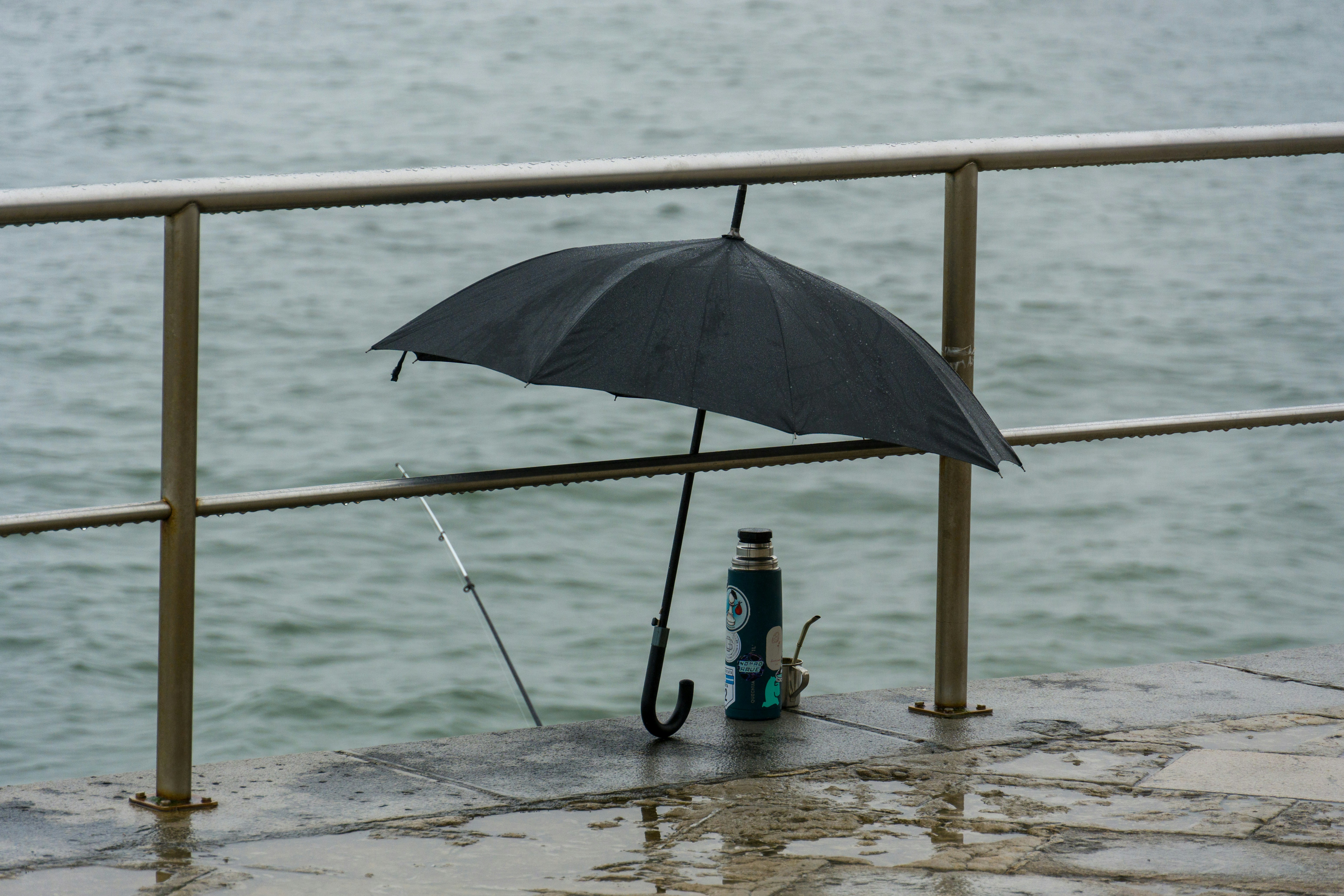 Umbrella at Rest on a Rain-Washed Pier, Guarding a Quiet Waterfront Moment