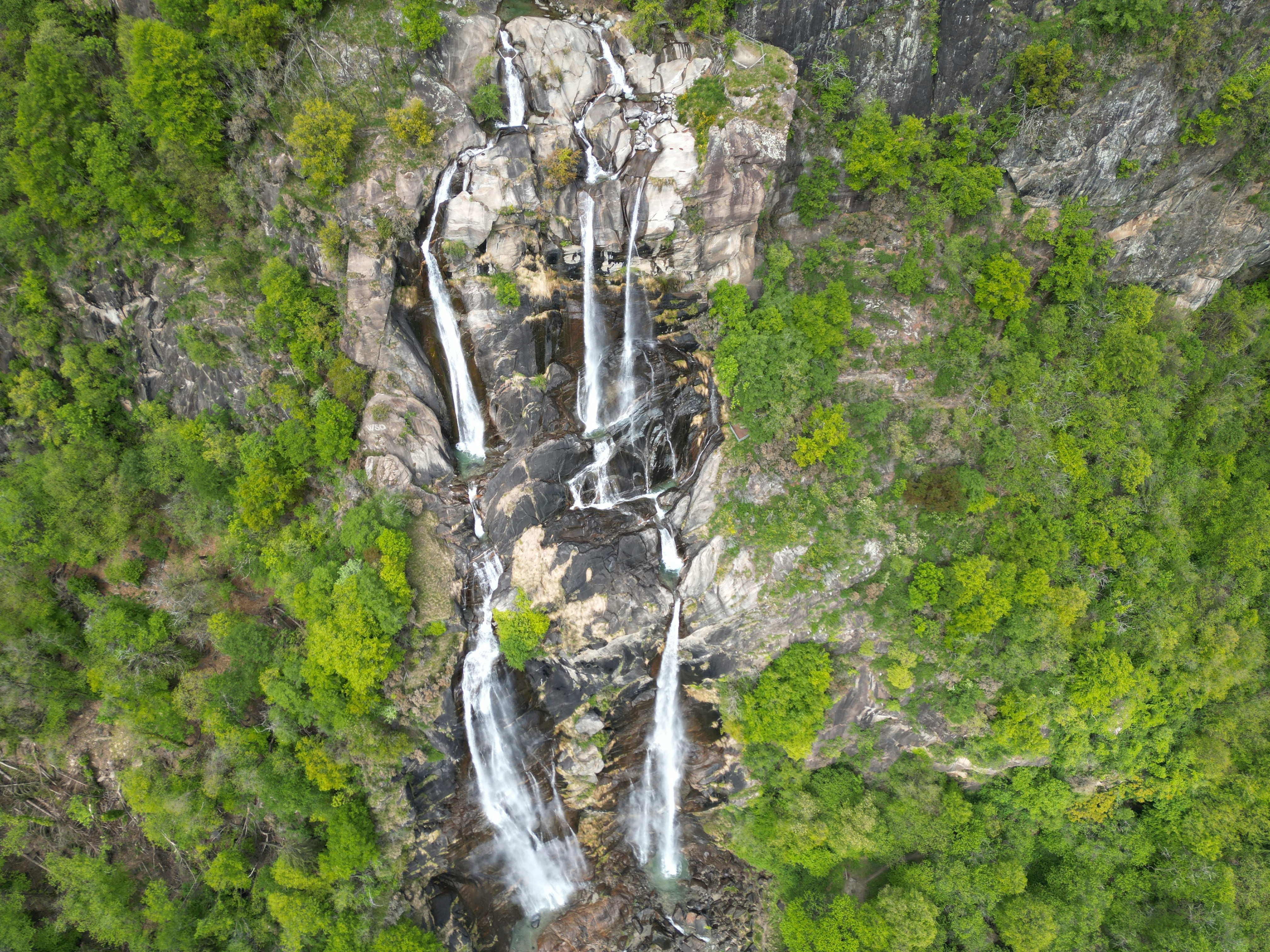 An aerial view of a waterfall surrounded by trees photo – Free Cascate ...