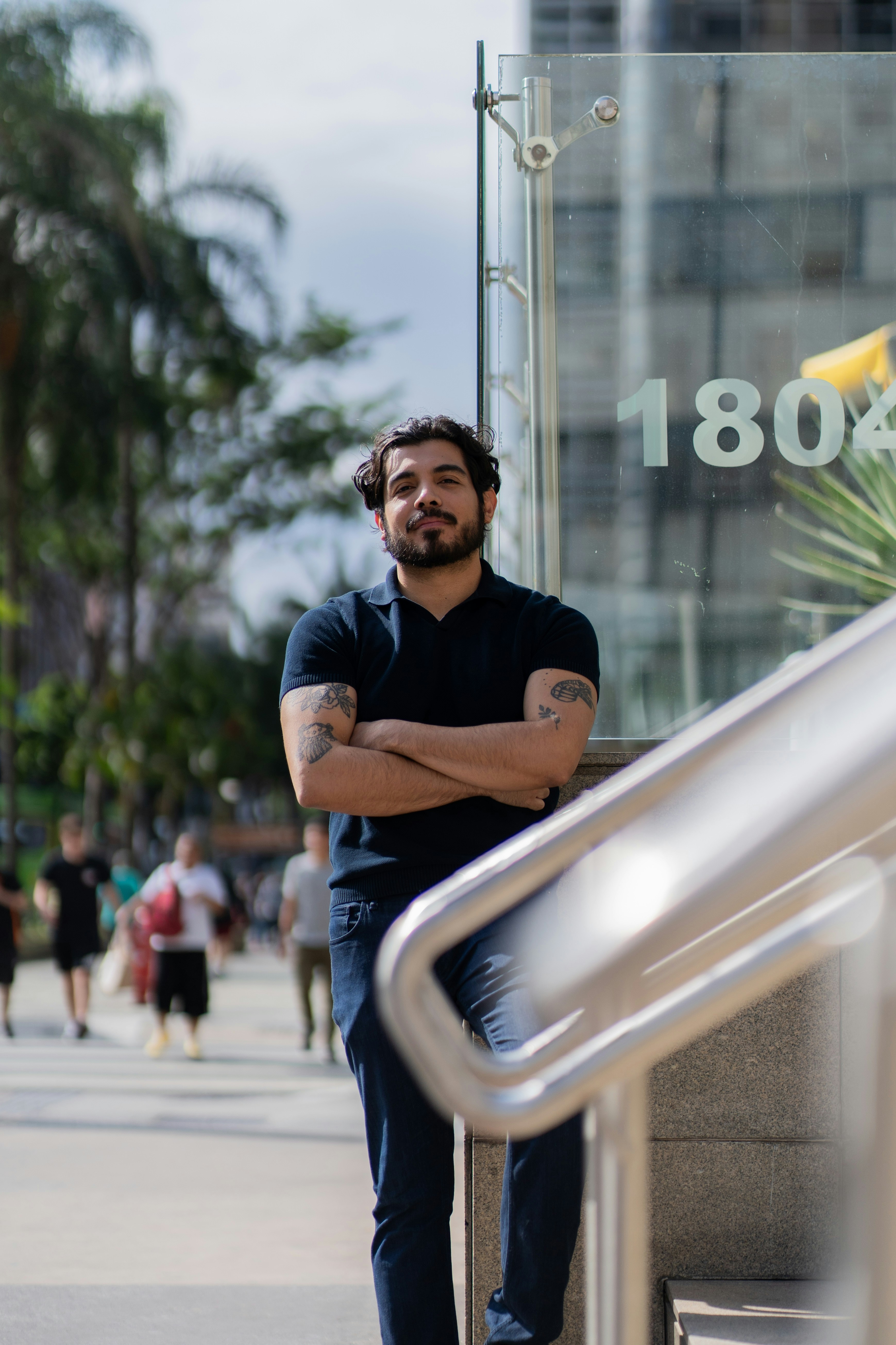 A man with his arms crossed leaning against a railing photo – Free Head ...