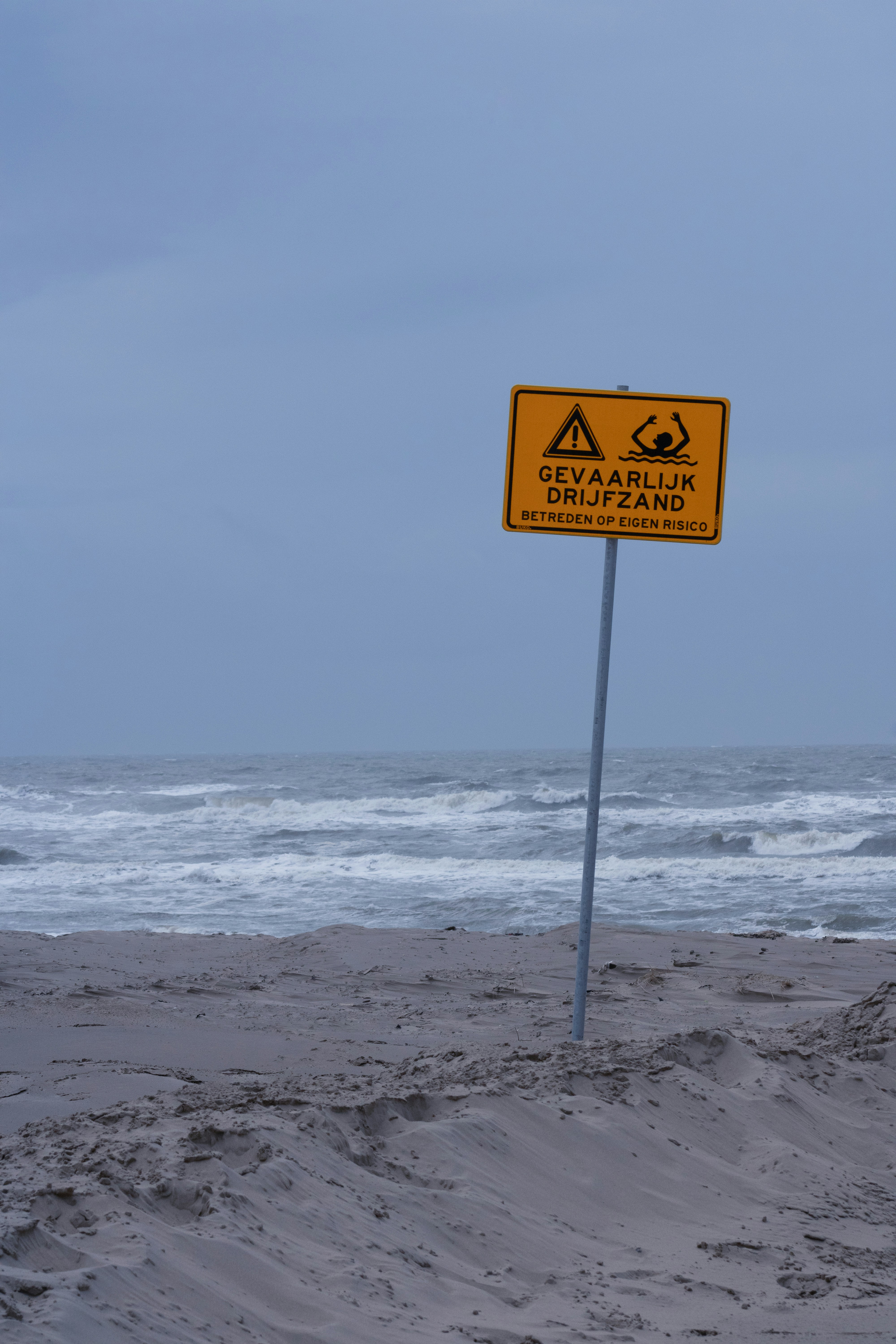 Dutch Drifting-Sand Warning Sign on a Windswept Beach