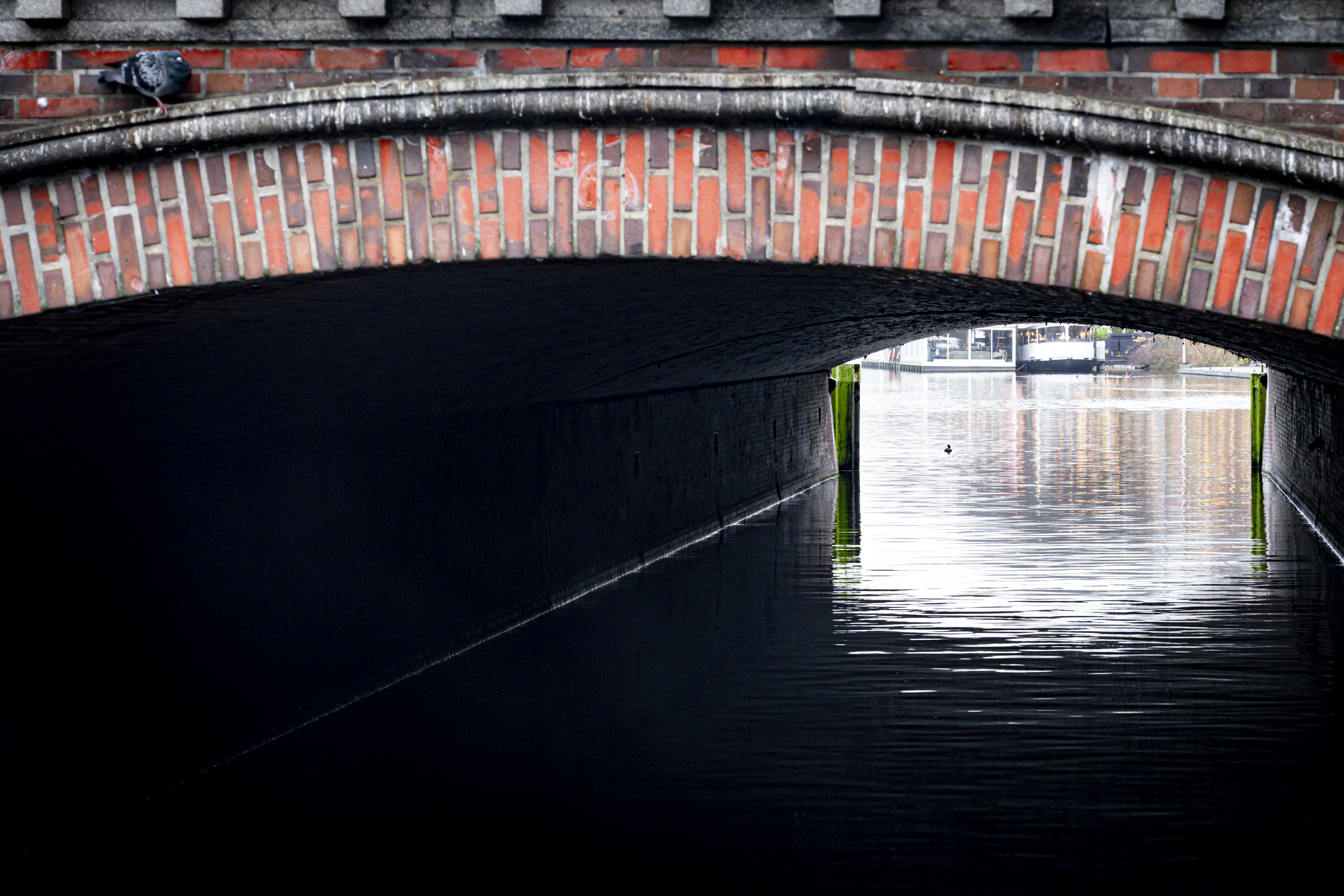 Brick Archway Toward a Sunlit Canal Exit