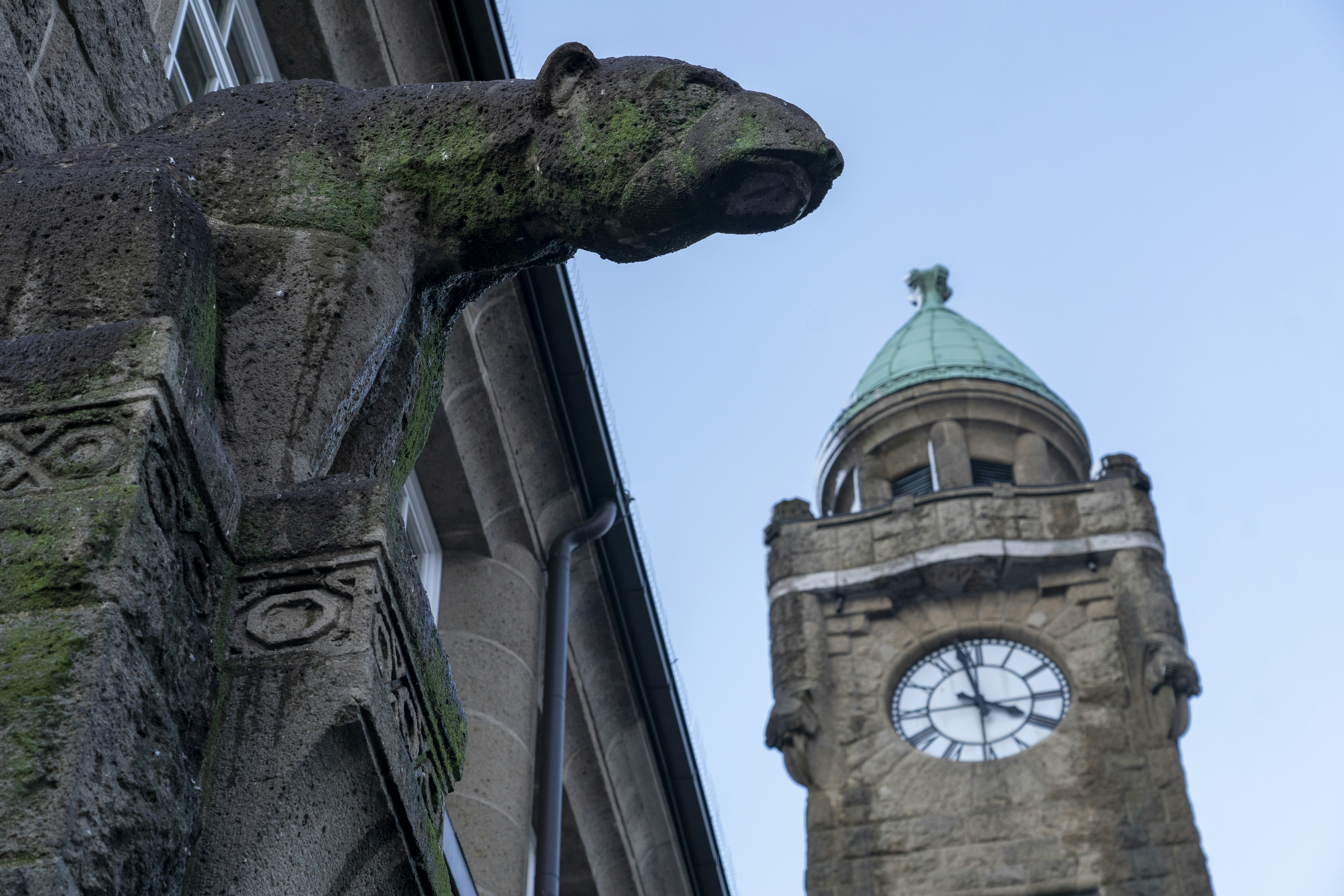Moss-Covered Stone Sentinel Framing a Clocktower Under a Clear Sky