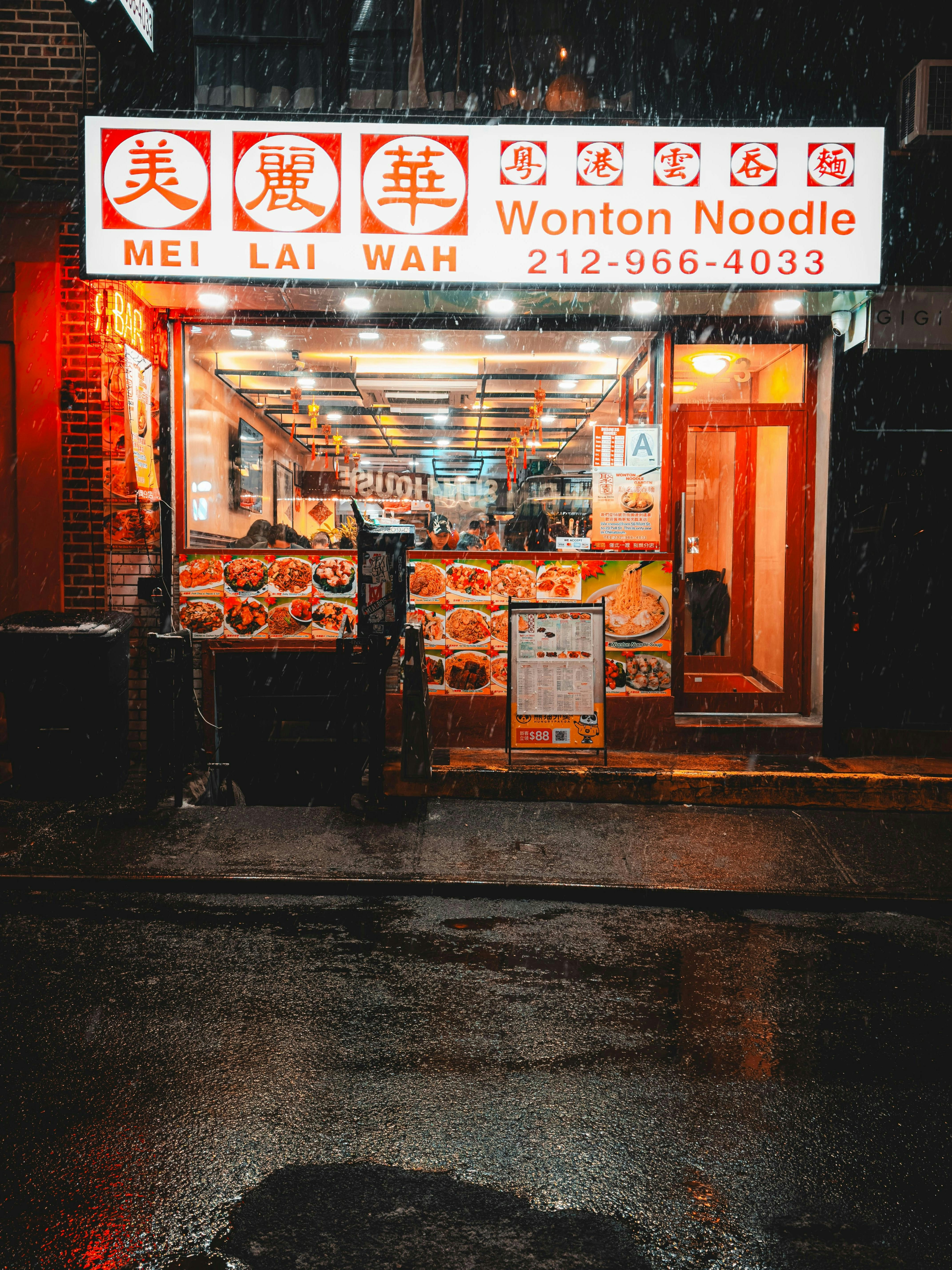 A street corner with a store front on a rainy night photo – Free ...