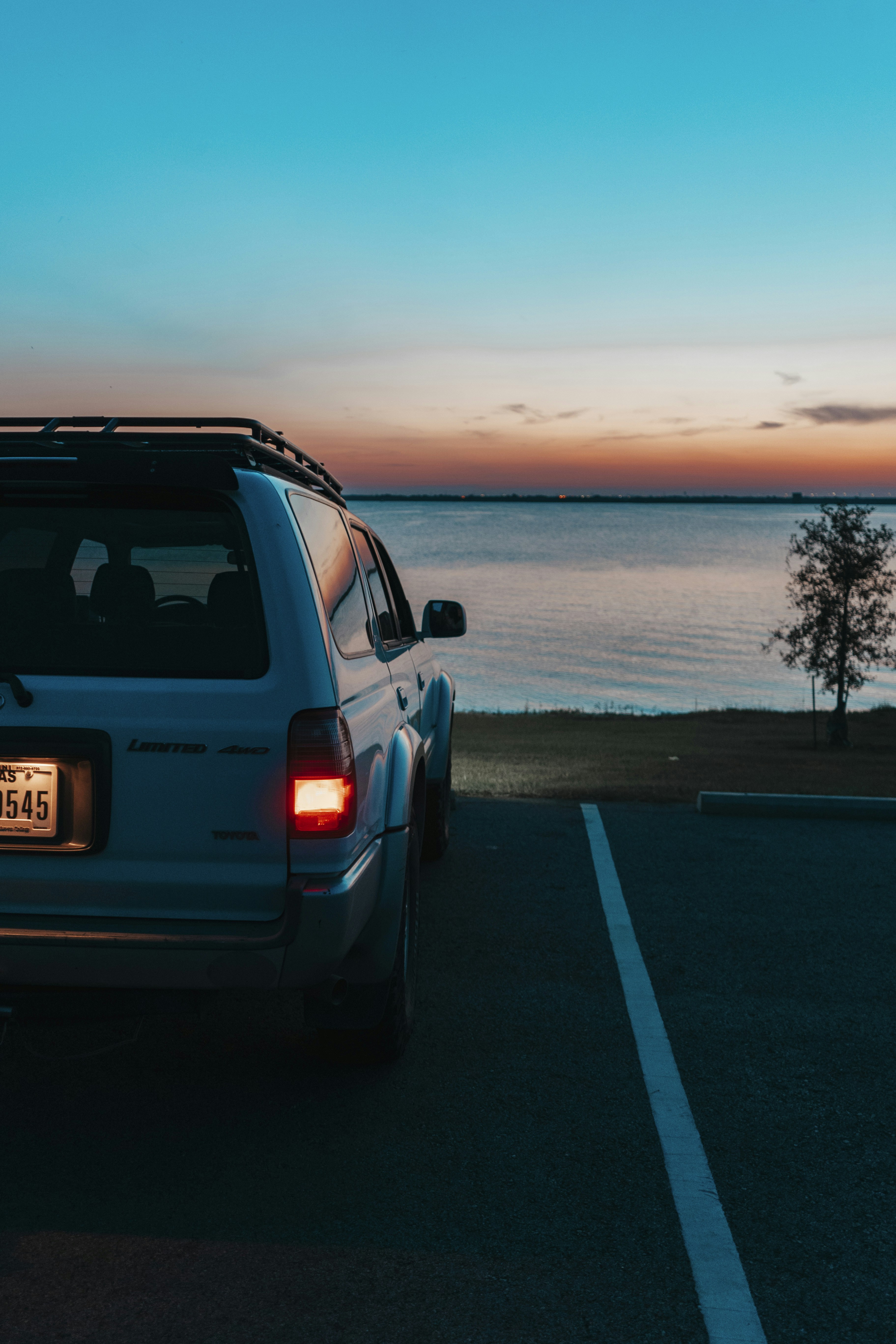 Lakeside Twilight Stopover: A Parked SUV at Sunset