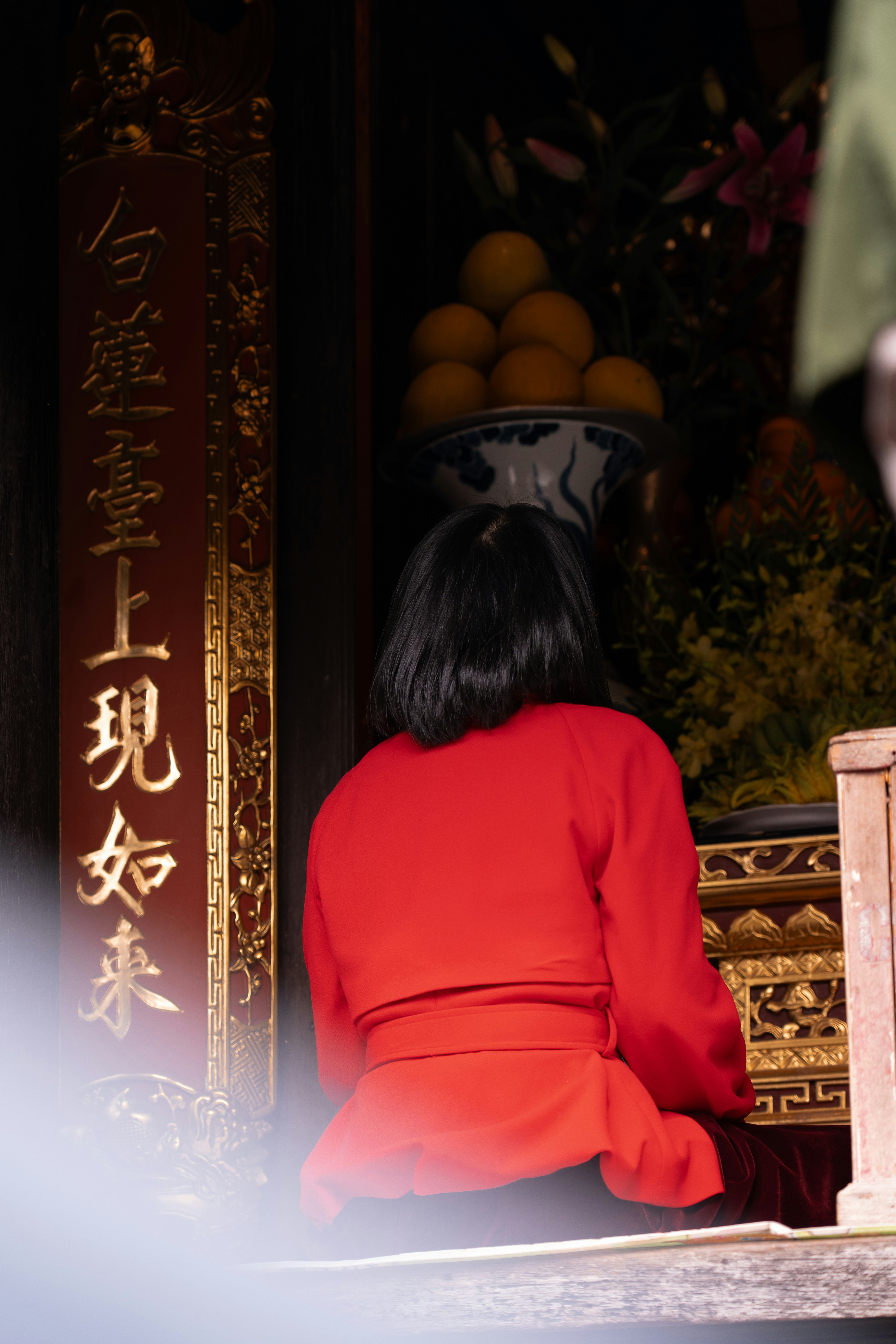 Red Garment Before Gold Altar: Quiet Reverence in a Temple Shrine