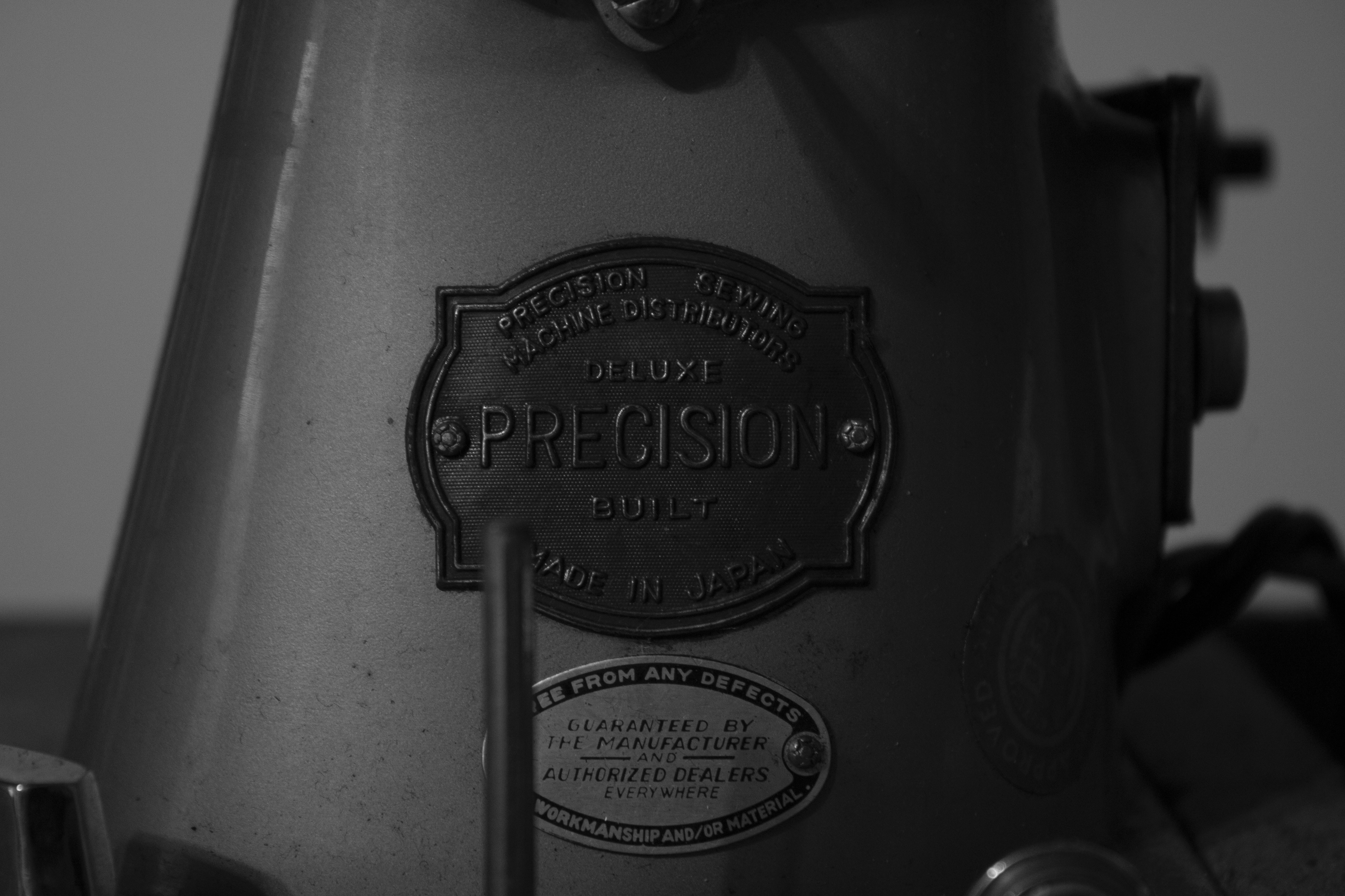 Close-up of a vintage metal plate showcasing the brand 'Precision Built' with intricate detailing. The craftsmanship highlights the quality and heritage of the equipment.