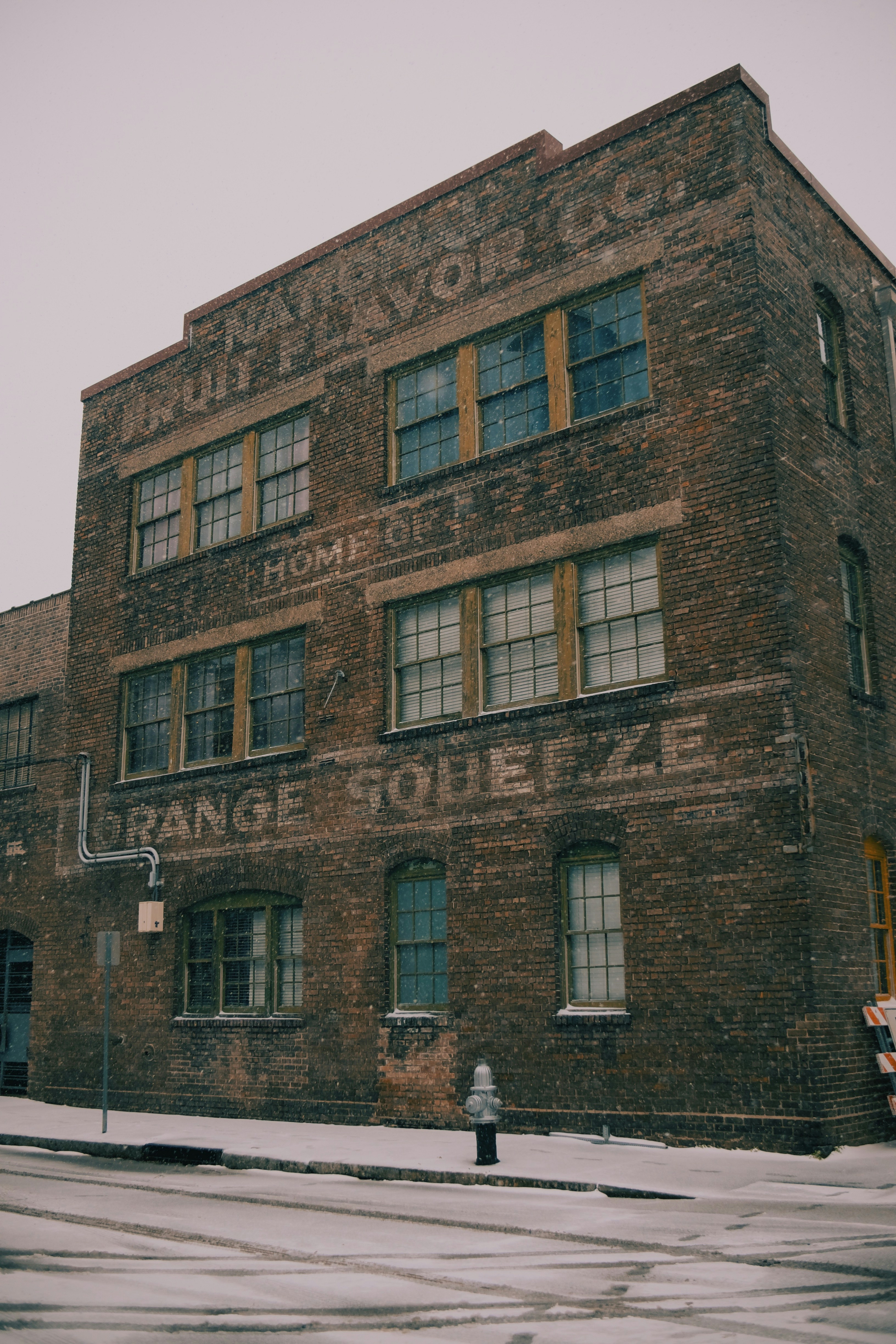 Snowbound Brickwork: Faded Signage on a Quiet Industrial Facade