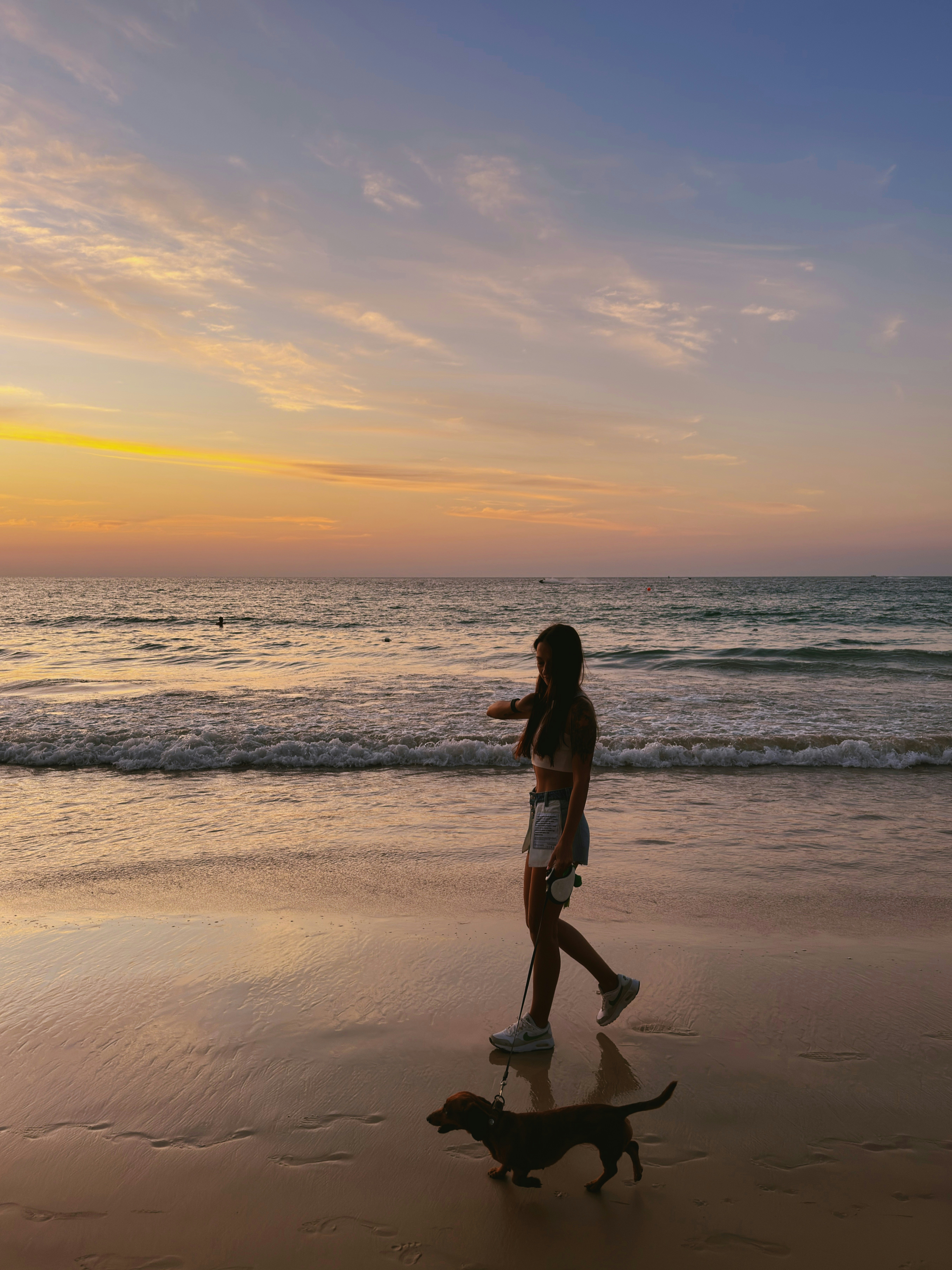 A woman walking a dog on a beach at sunset photo – Free Bang tao beach ...