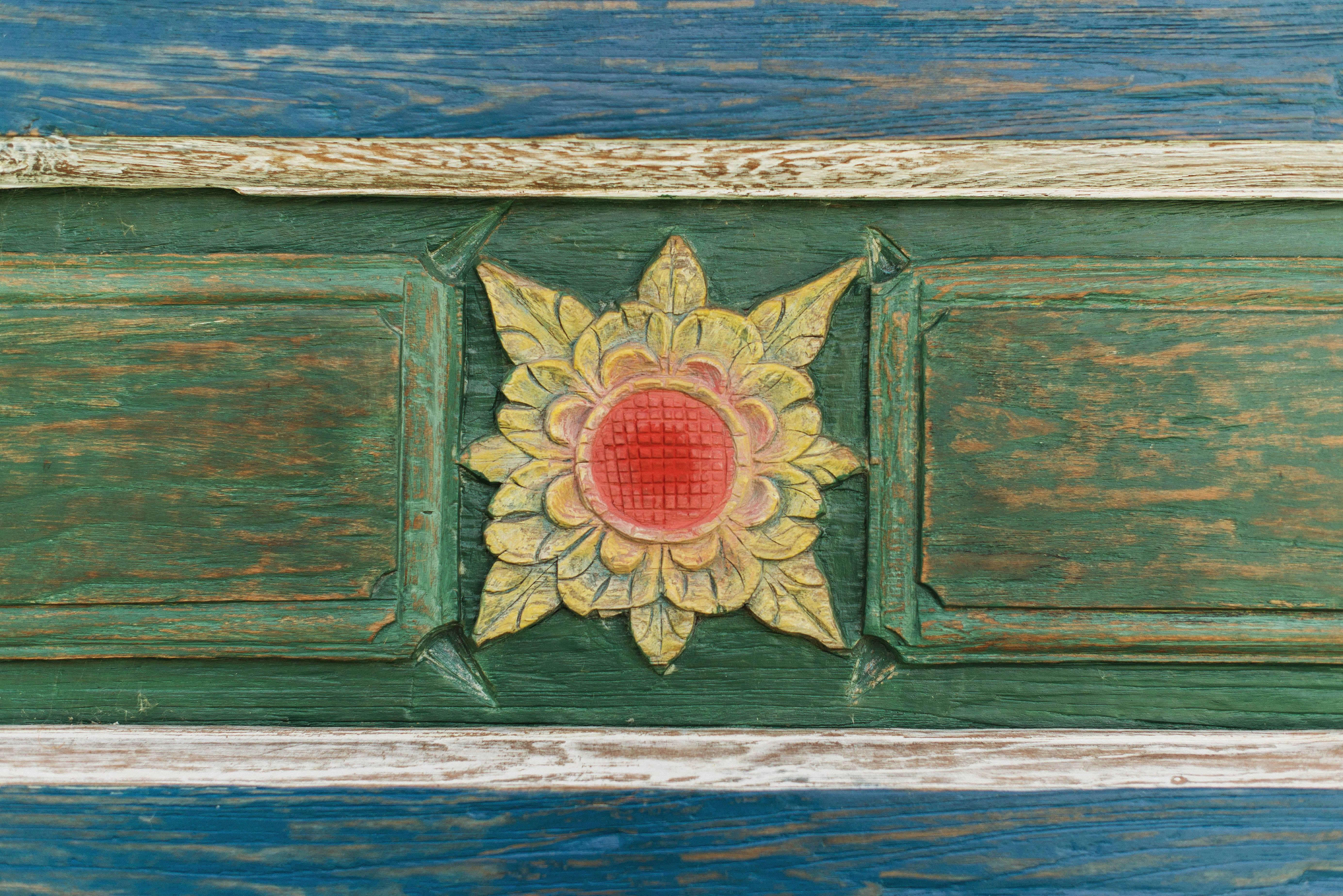 Verdigris Panel Bloom: A Weathered Green Door with a Sunflower Medallion