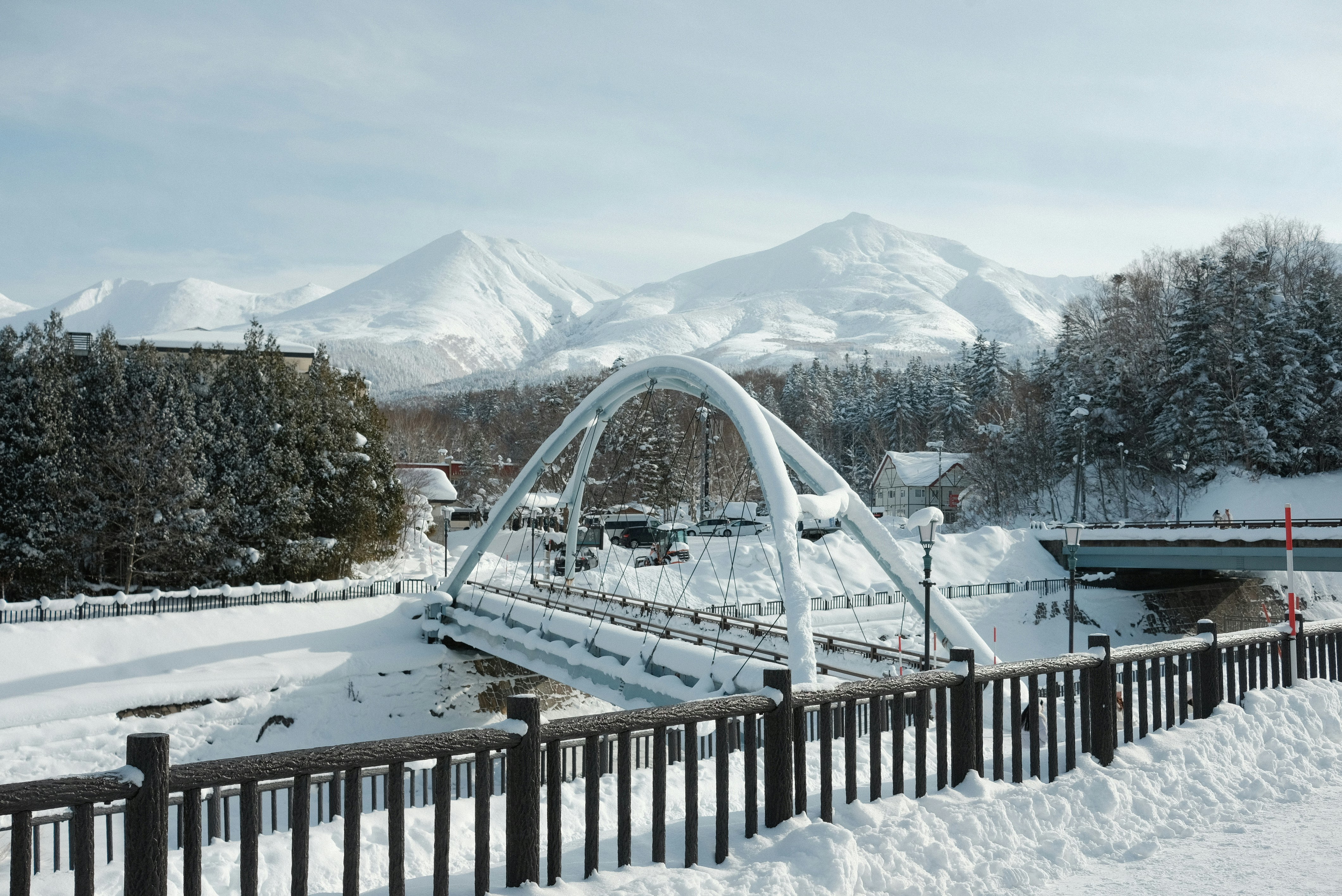 Snowlit Arch Over a Frozen River: A Winter Crossing Beneath Alpine Peaks