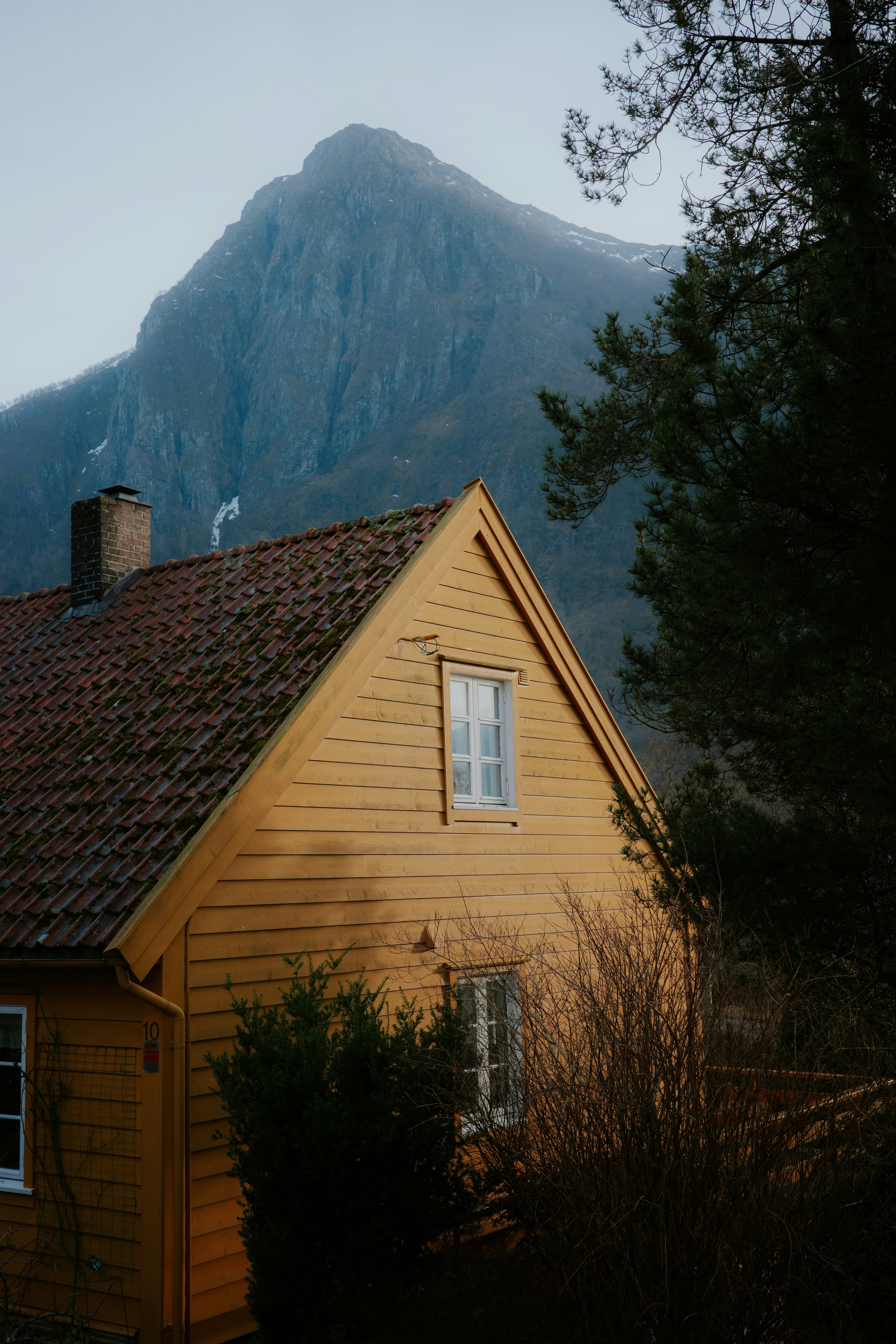 Amber Cottage Framed by a Stoic Alpine Peak