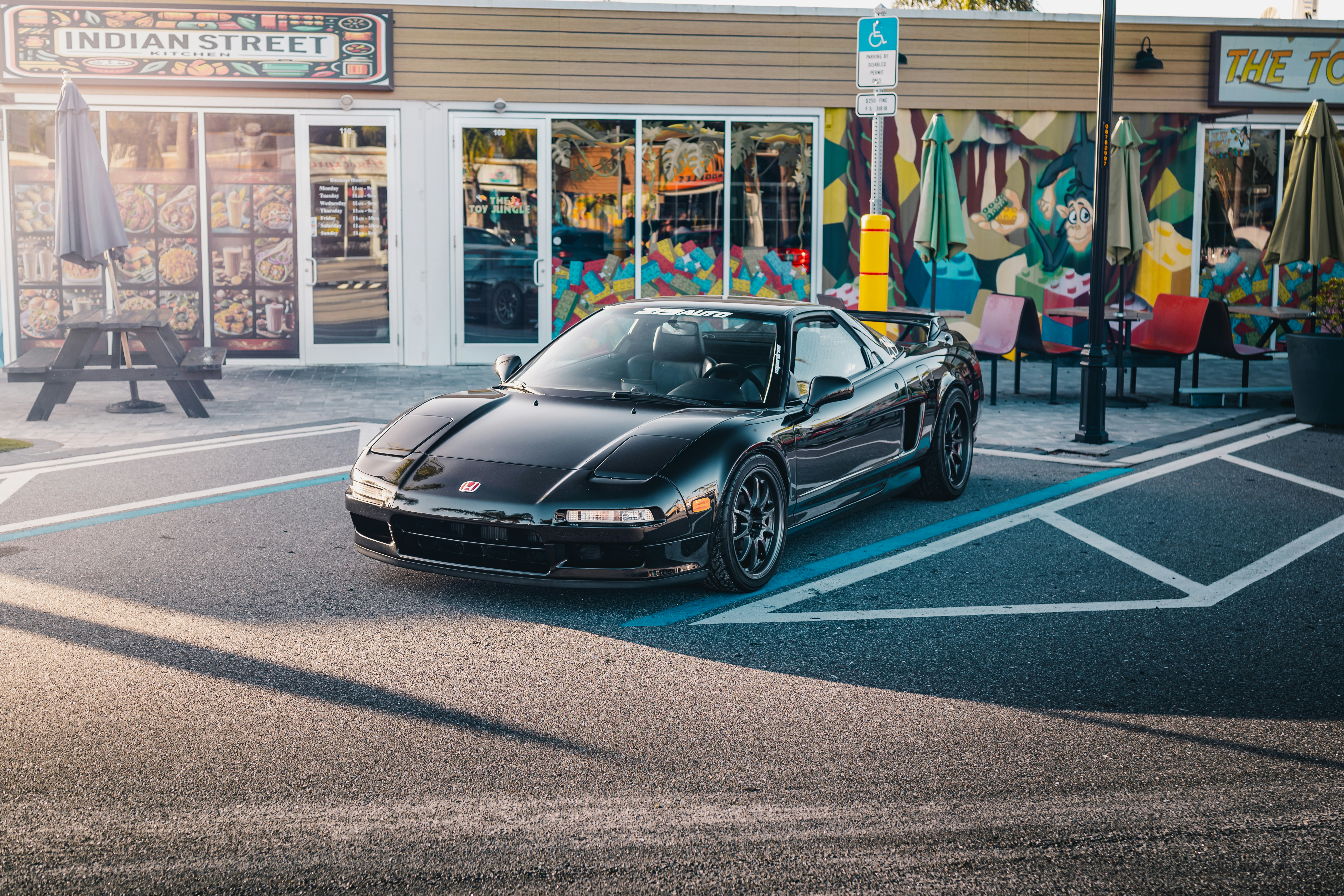 Urban Elegance: Black Sports Car Meets Kaleidoscopic Backdrop