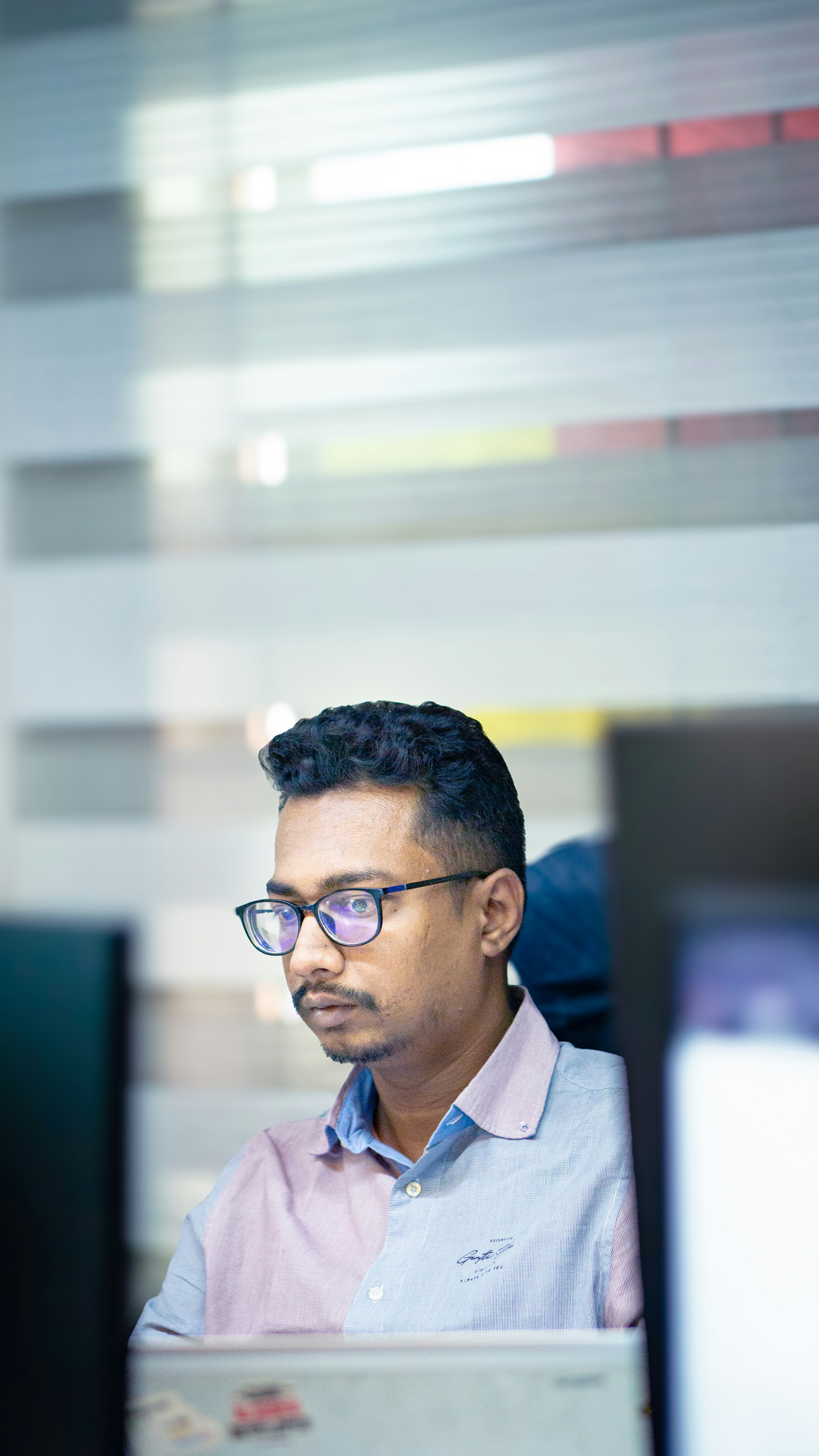 A man sitting in front of a laptop computer photo – Free Office Image ...