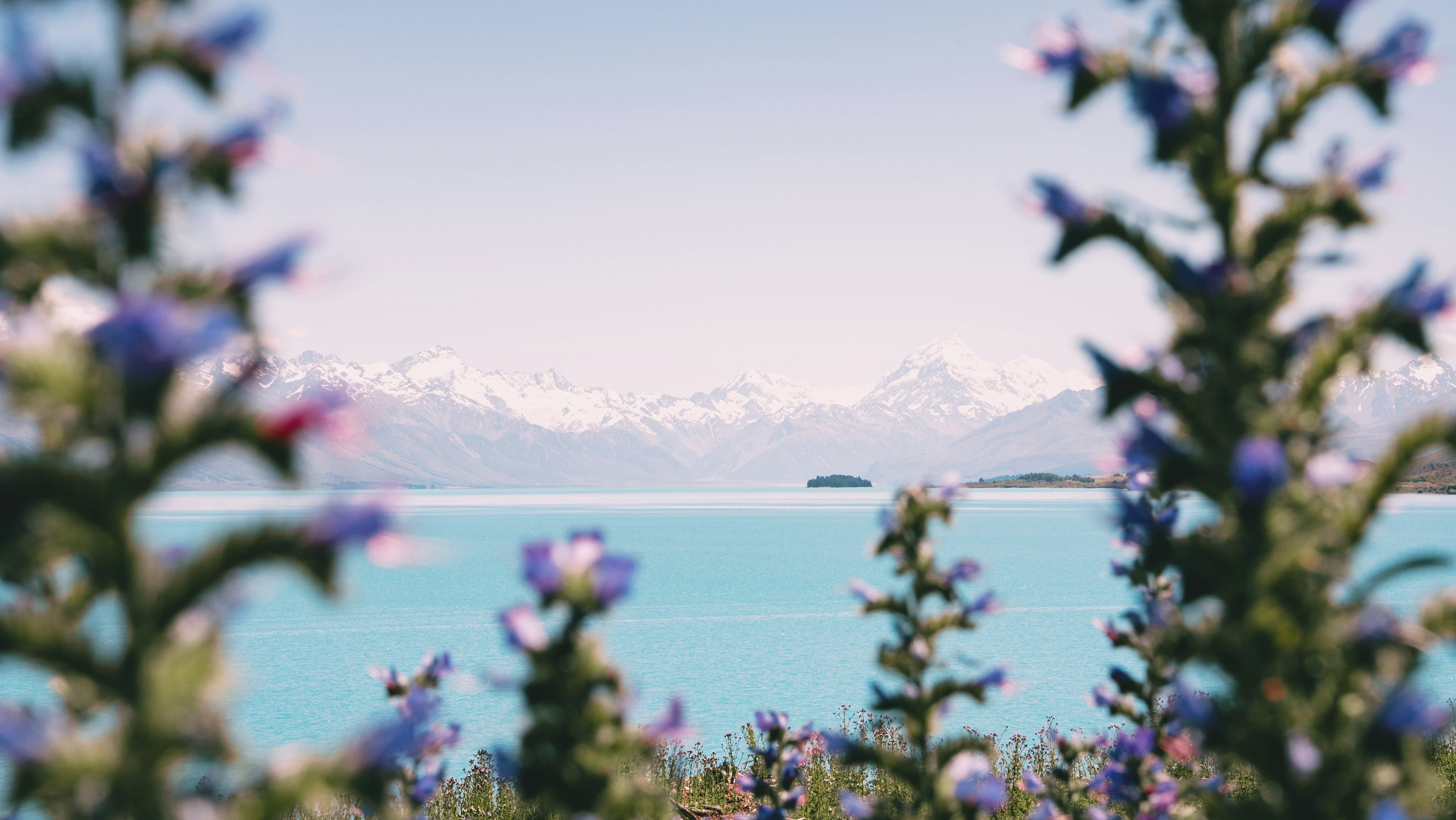 Horizon Blue: Snow-Tipped Peaks Beyond Turquoise Waters
