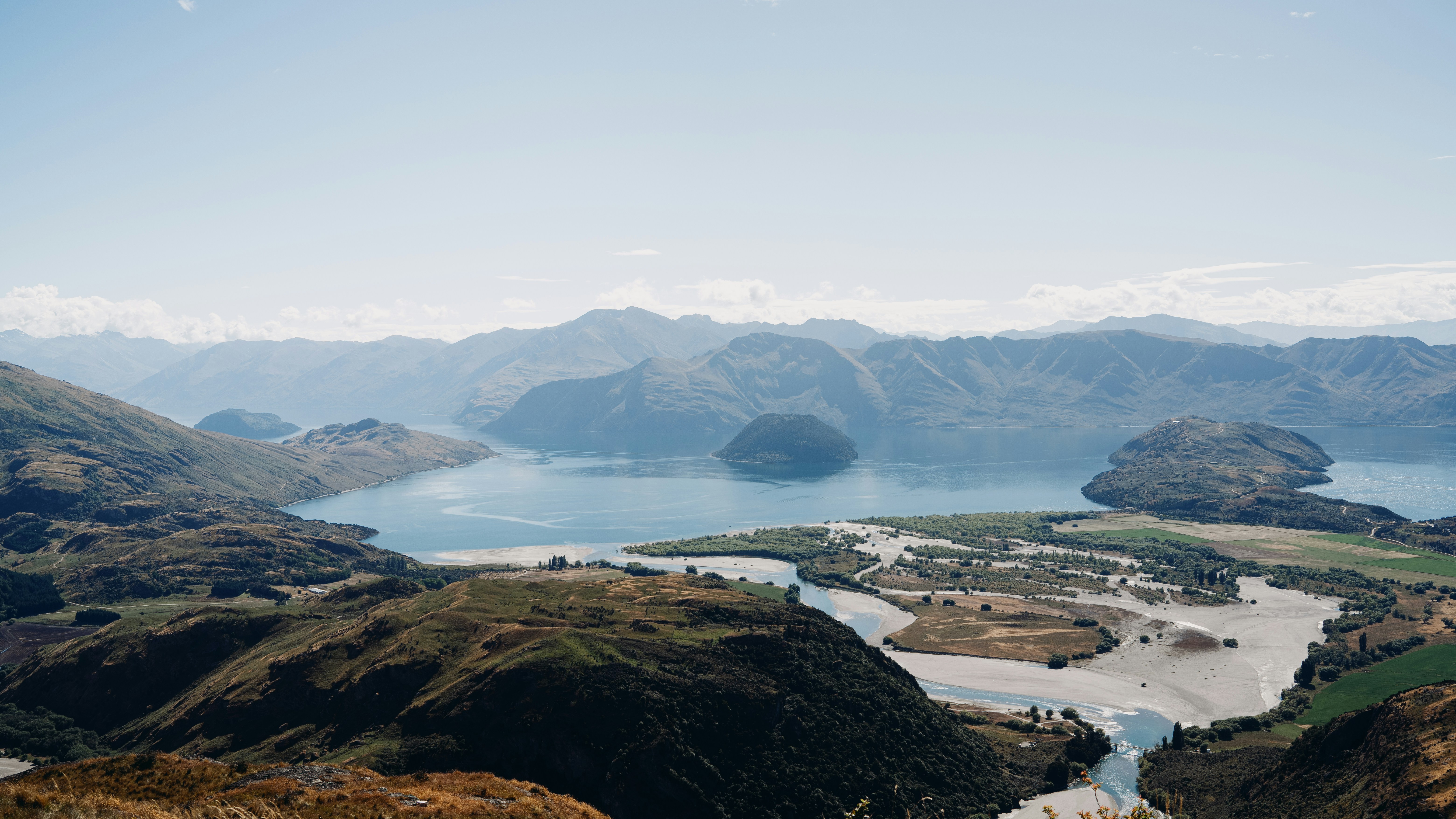 Expansive lake surrounded by rugged mountains under a clear sky.