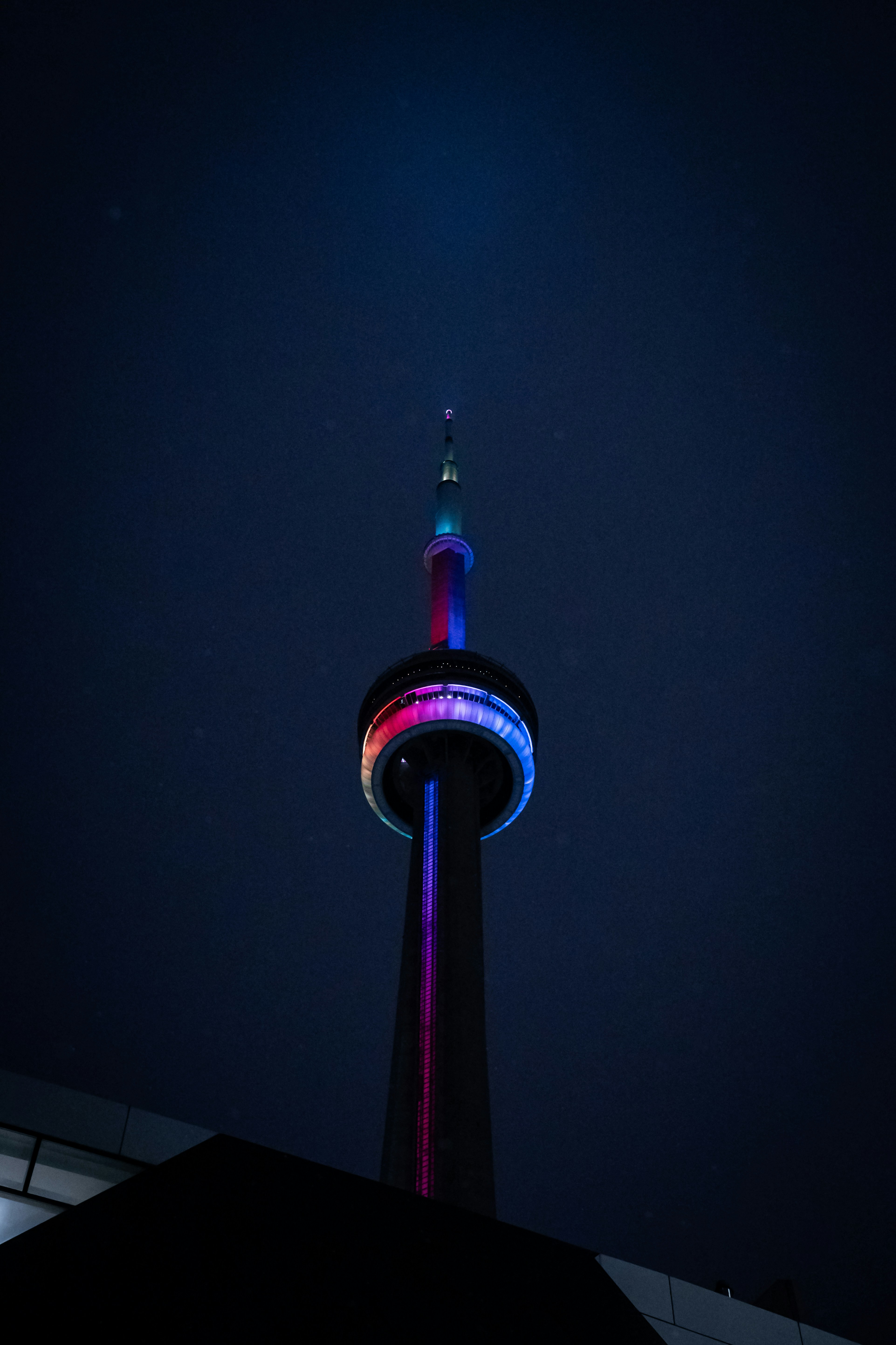 A very tall tower with a very colorful light on it's side photo – Free ...