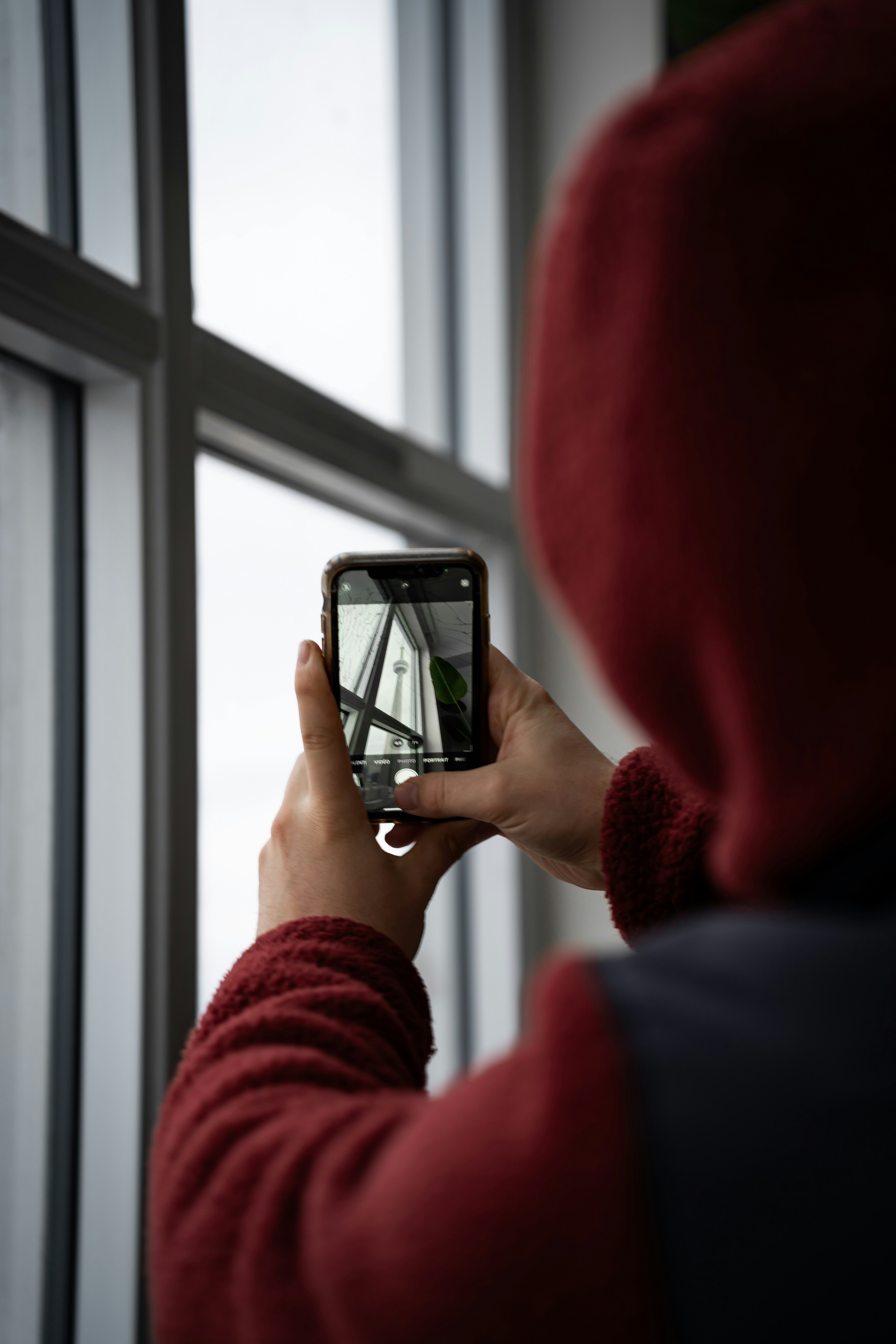 A person taking a picture of a window with a cell phone photo – Free ...