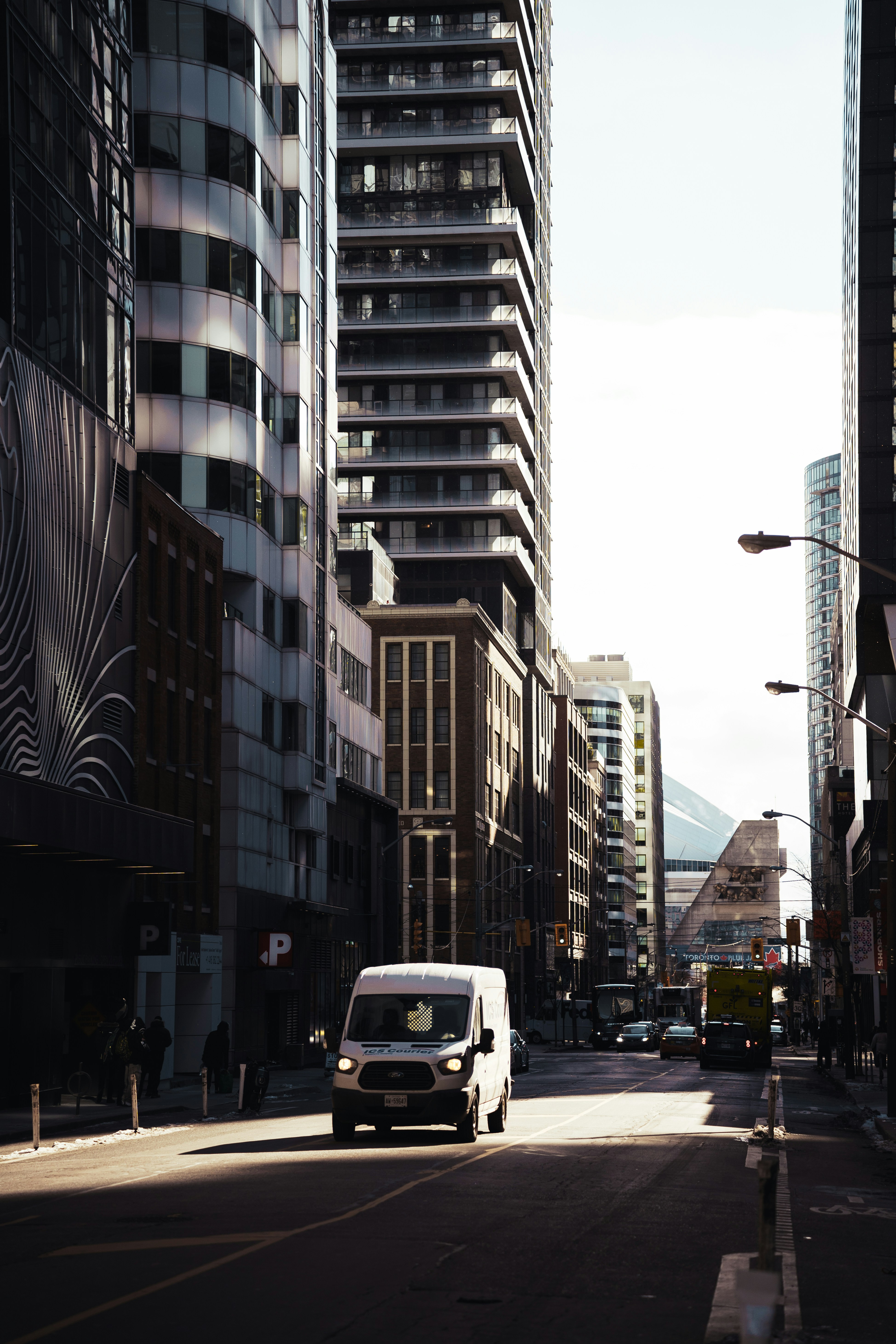 A van driving down a city street next to tall buildings photo – Free ...