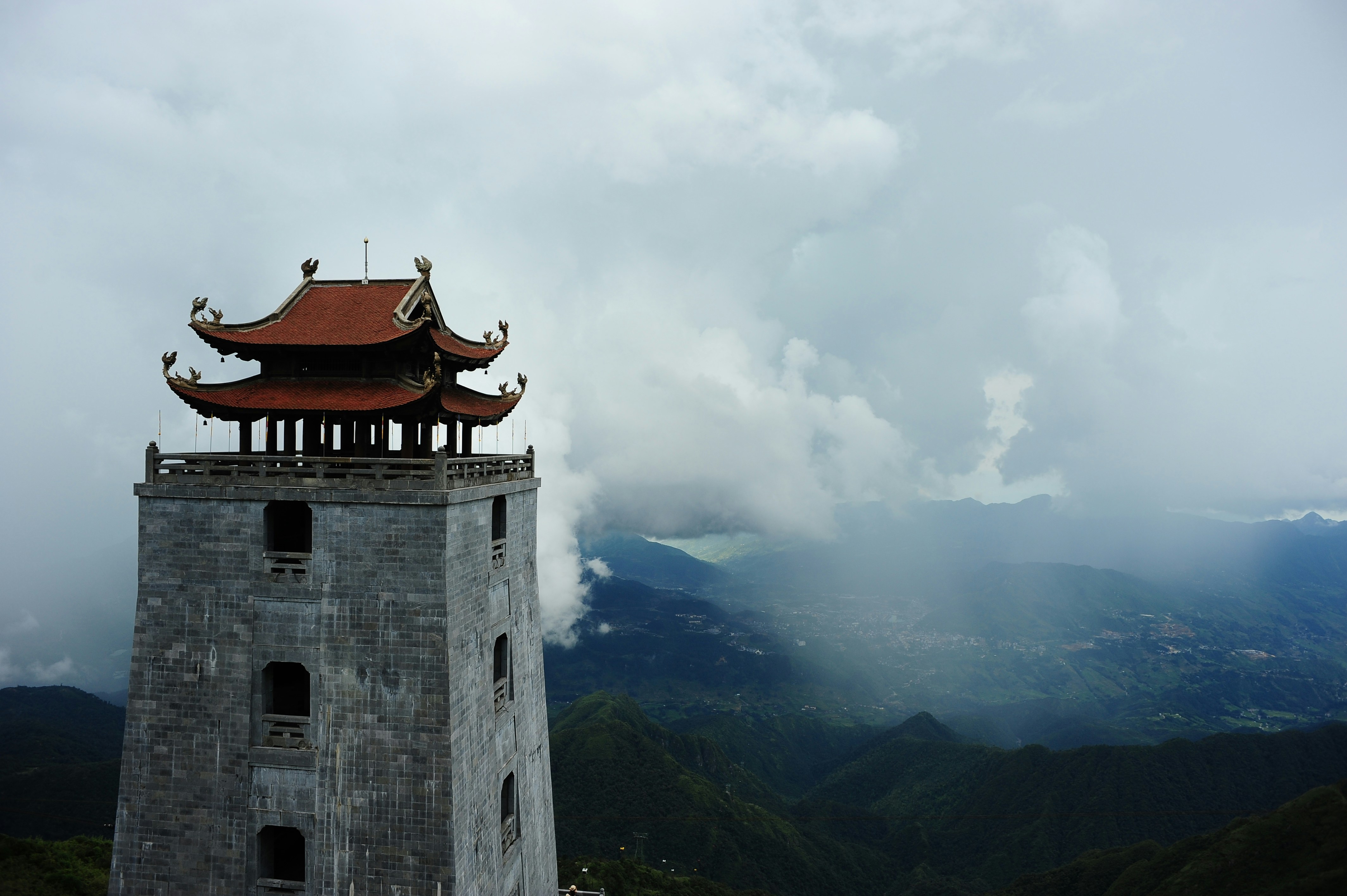 A tall tower with a red roof on top of a mountain photo – Free Scenery ...