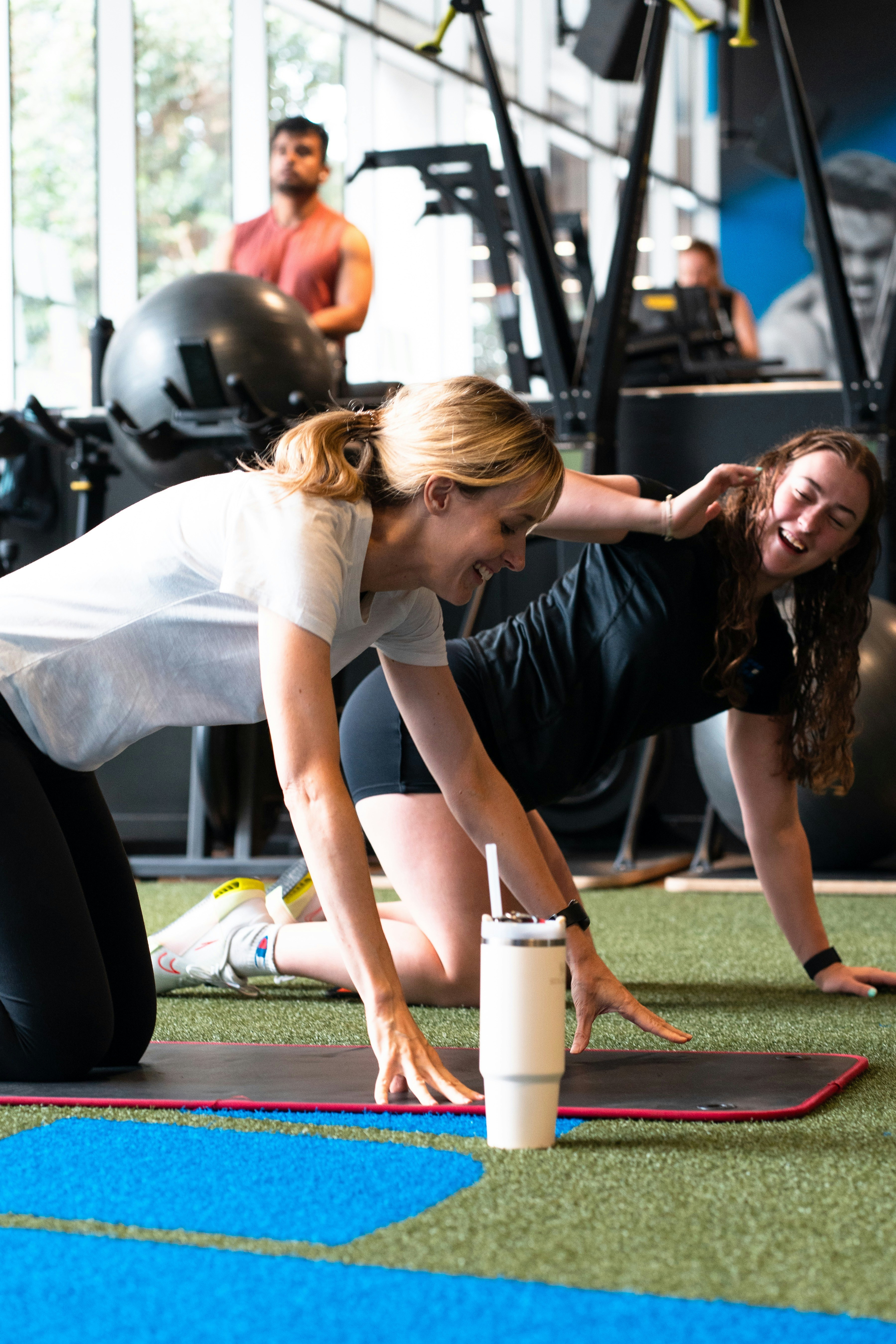 Fit Friends on the Mat: Mid-Workout Laughs in a Modern Gym