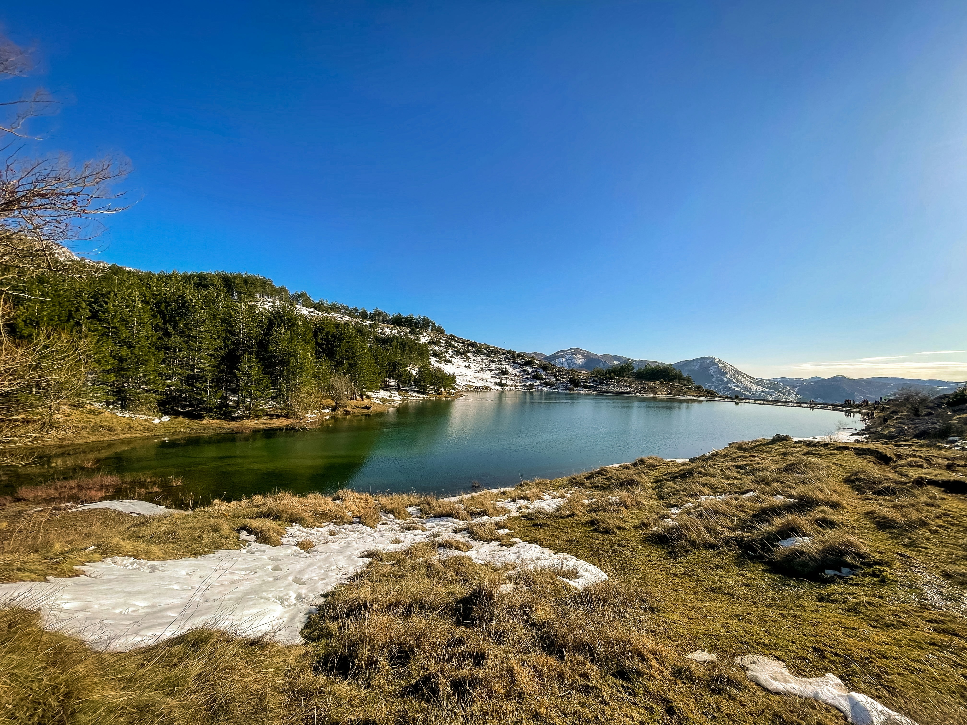 Un lac au milieu d’un champ avec de la neige au sol photo – Image ...