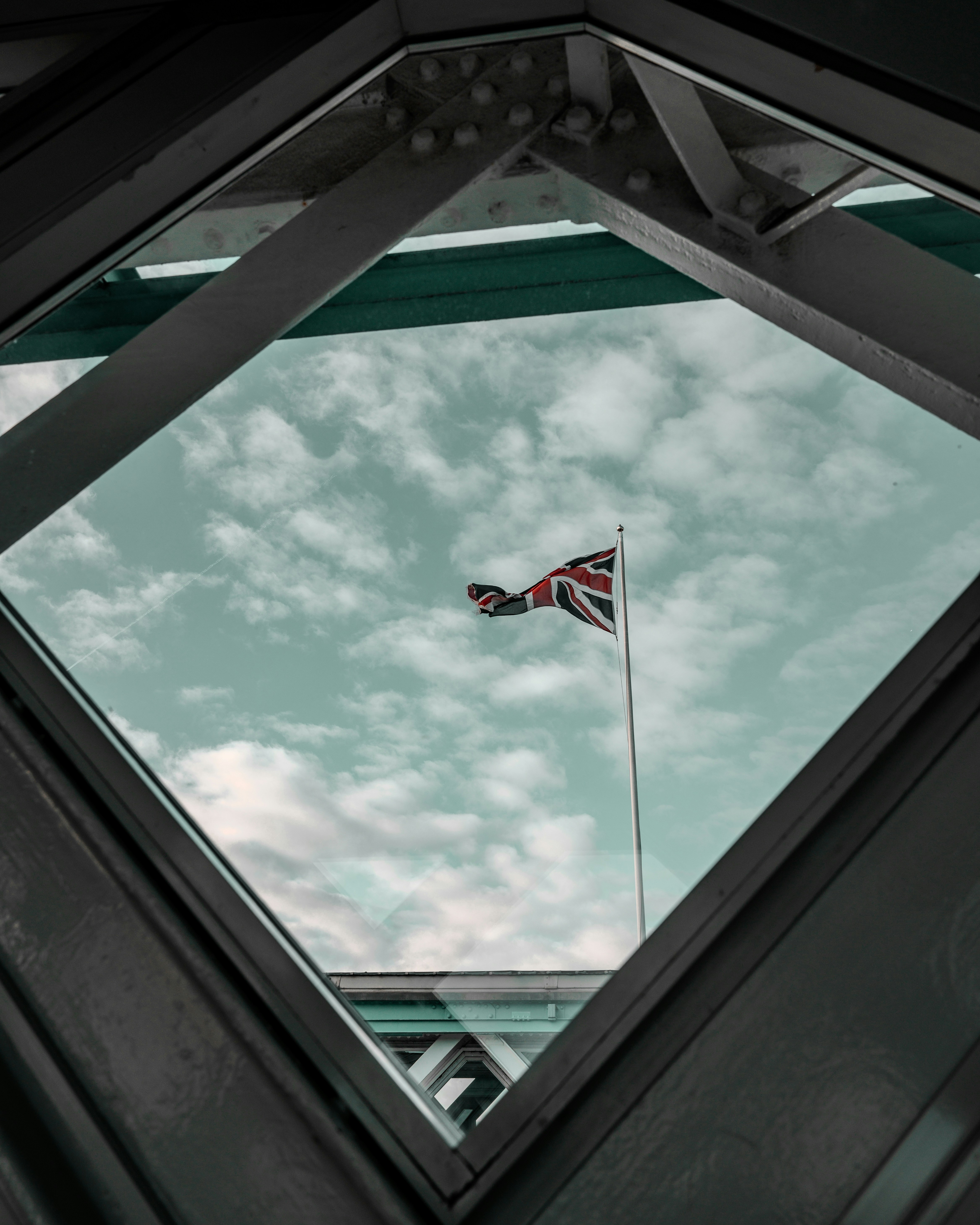 A view of a british flag flying from the top of a building photo – Free ...