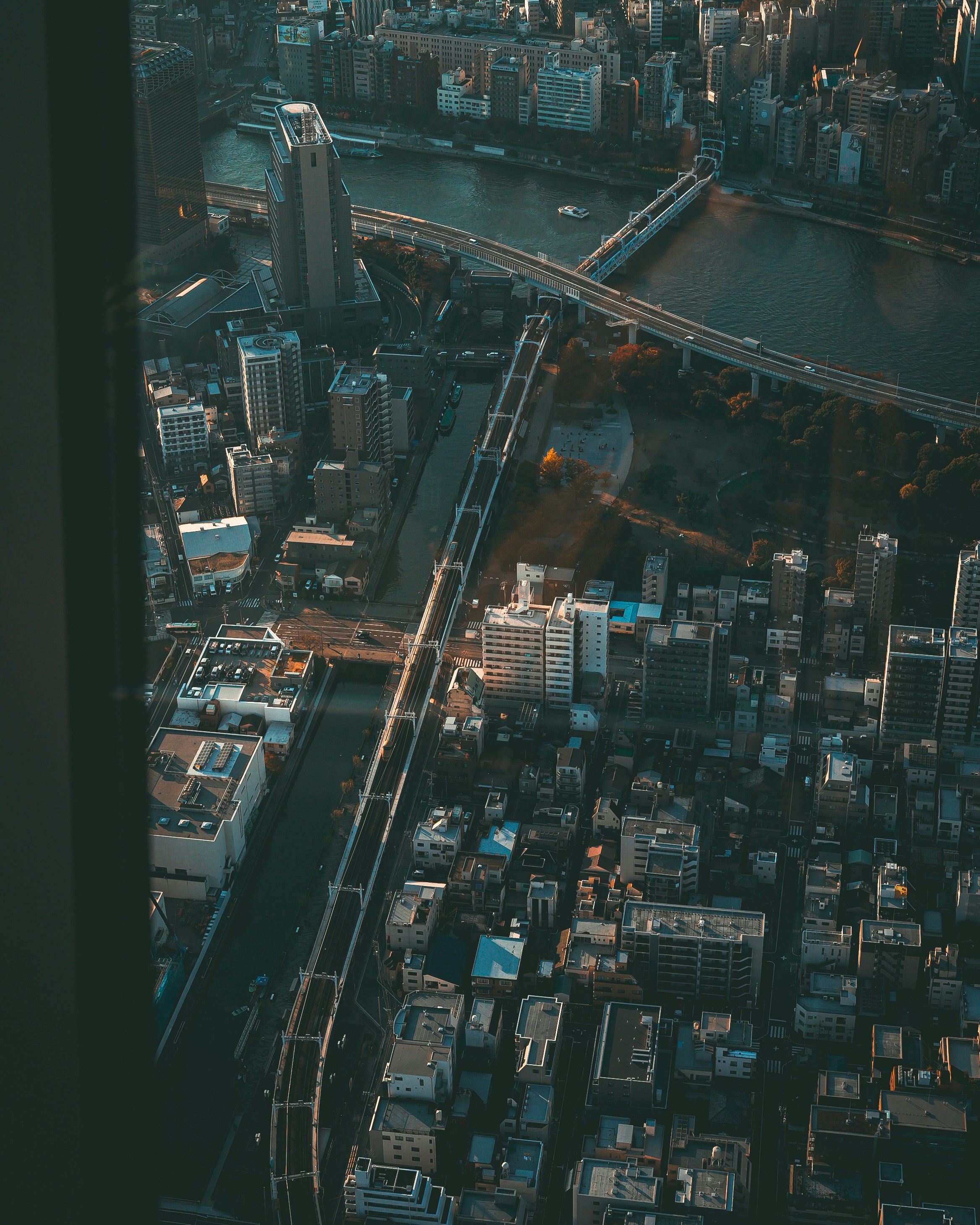 Ribbons of Steel and River: A Dusk-Blue Cityscape from Above