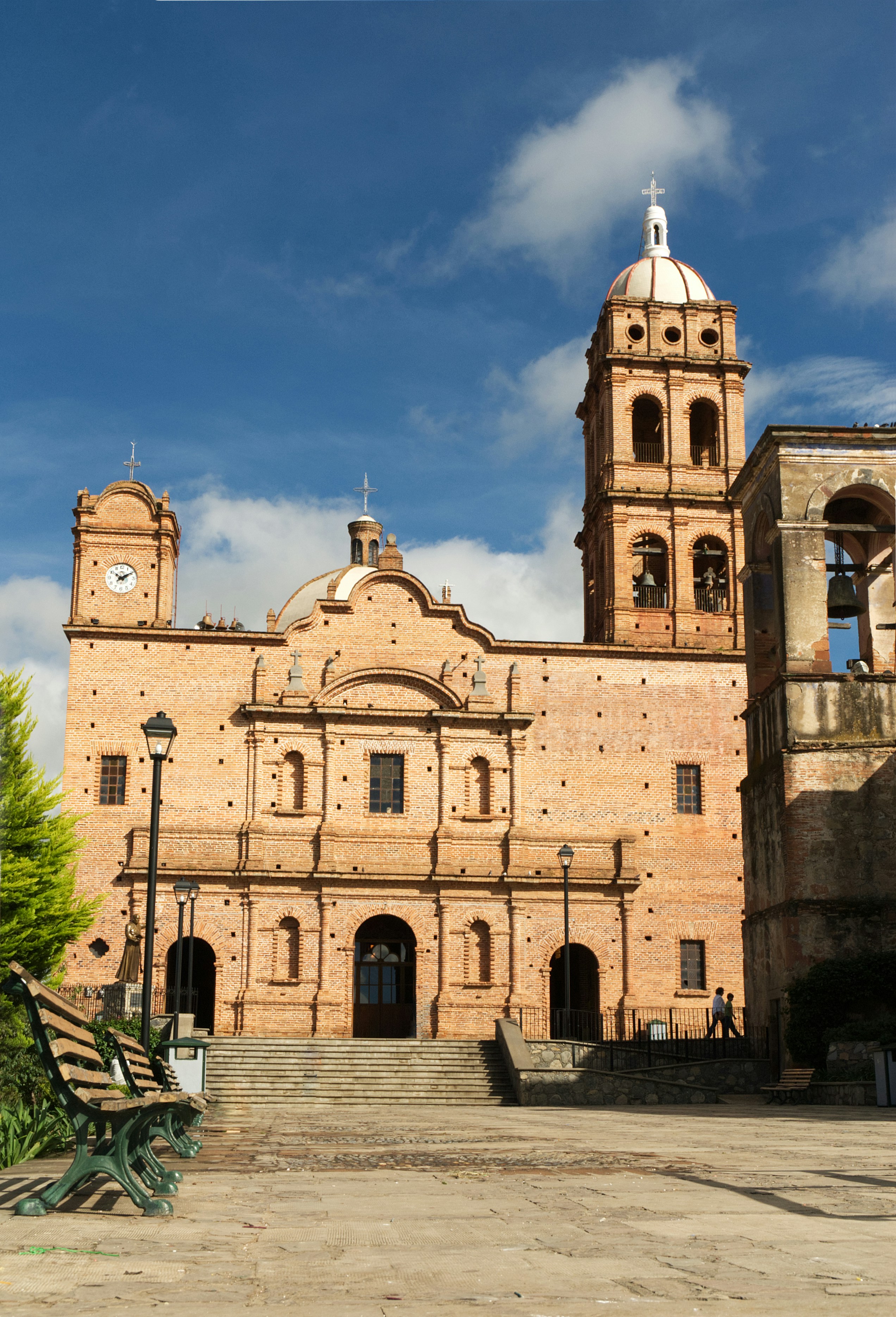 Historic church with twin bell towers against a bright blue sky in Talpalpa, Jalisco.