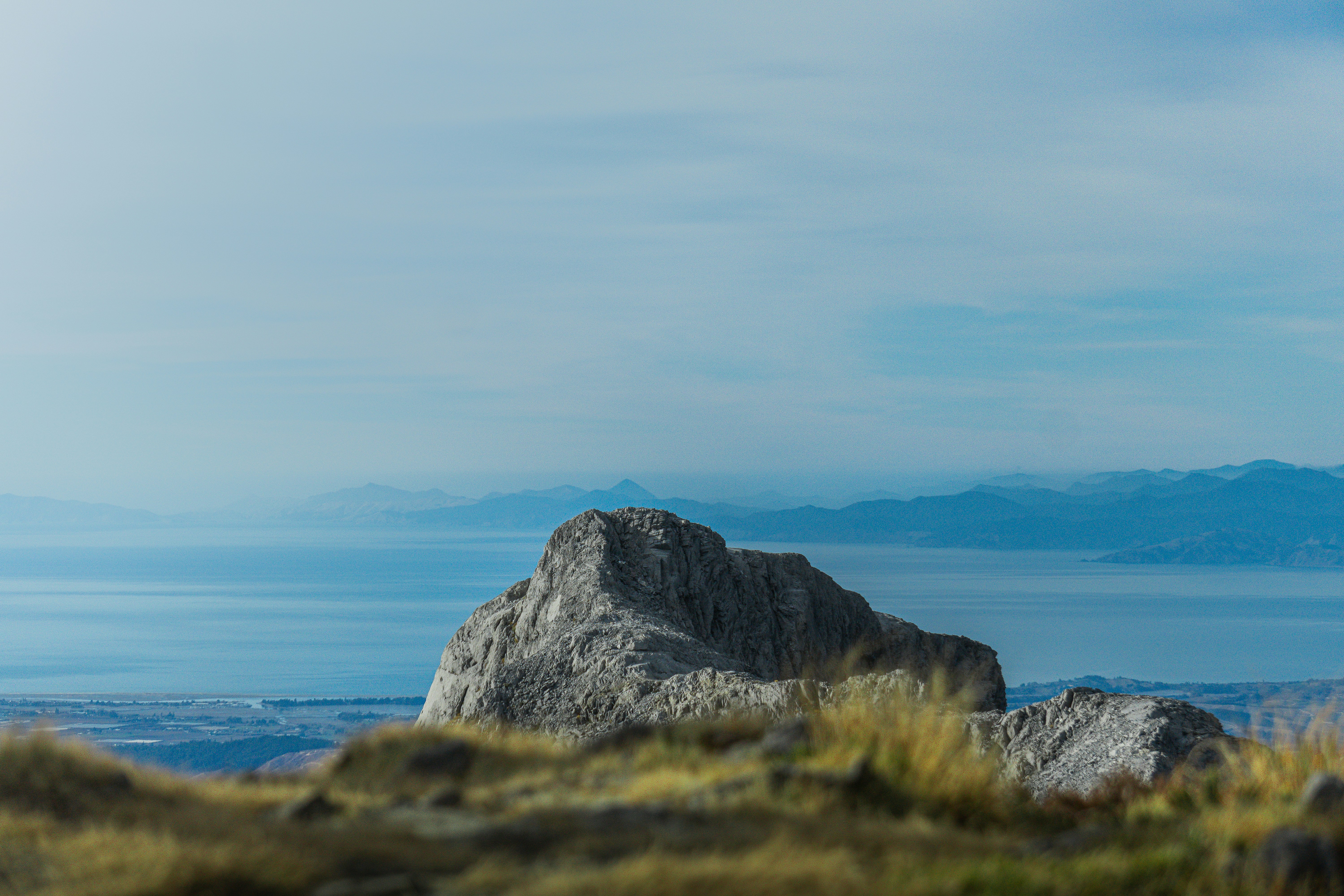 A large rock sitting on top of a lush green field photo – Free Mountain ...