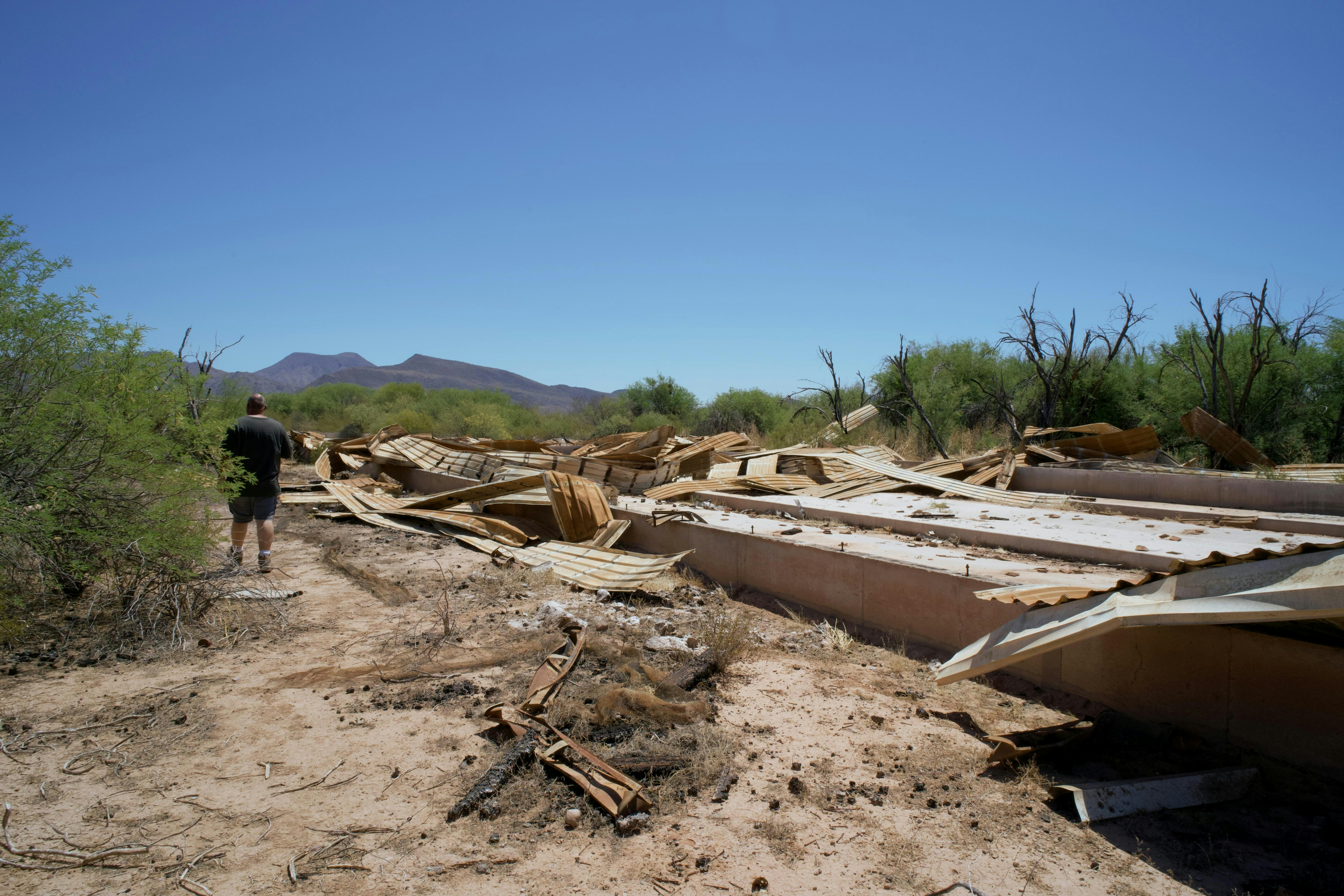A man standing next to a bunch of boats on a dirt road photo – Free Man ...