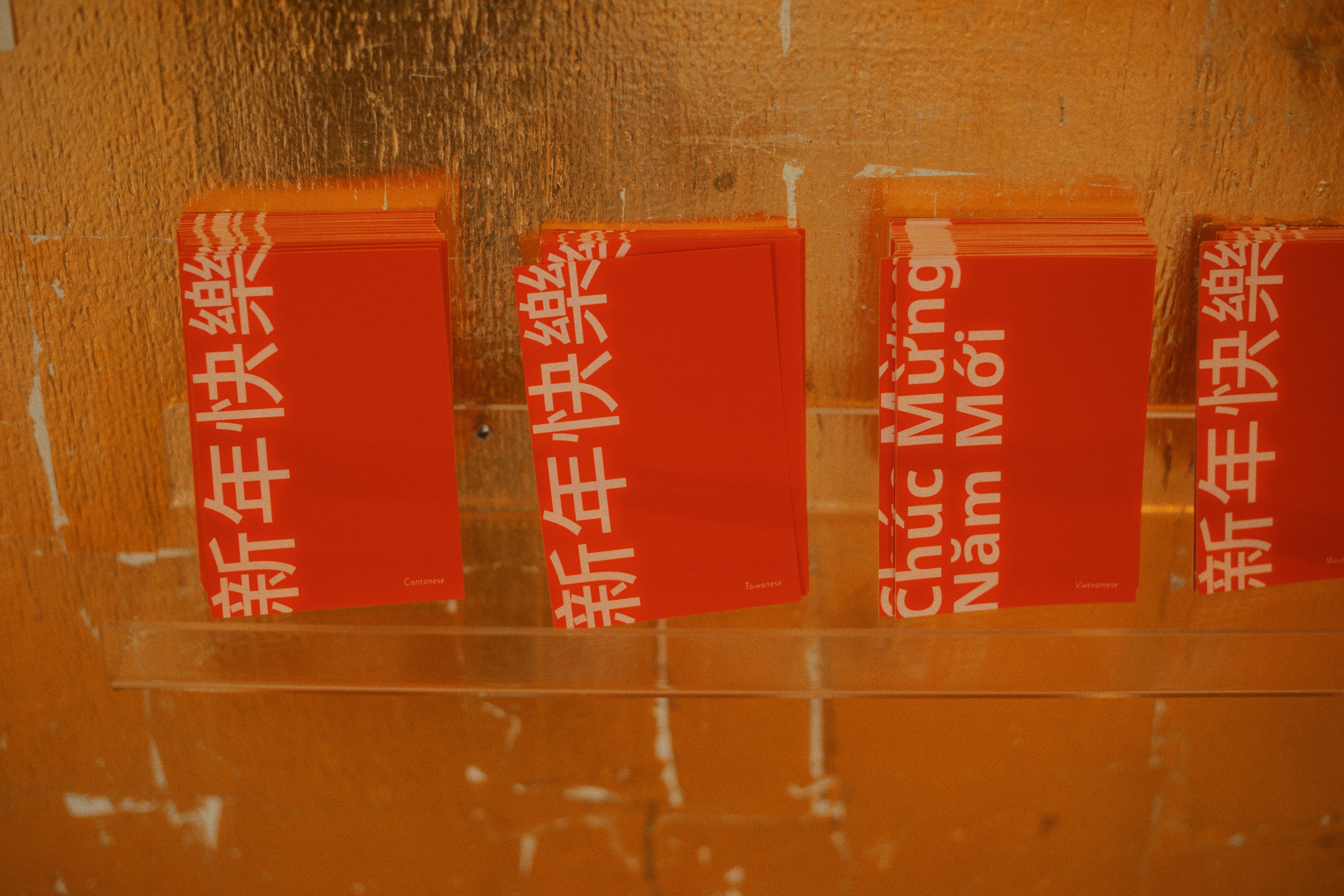 Minimal Still Life: Red-Orange Packaging on a Weathered Amber Surface