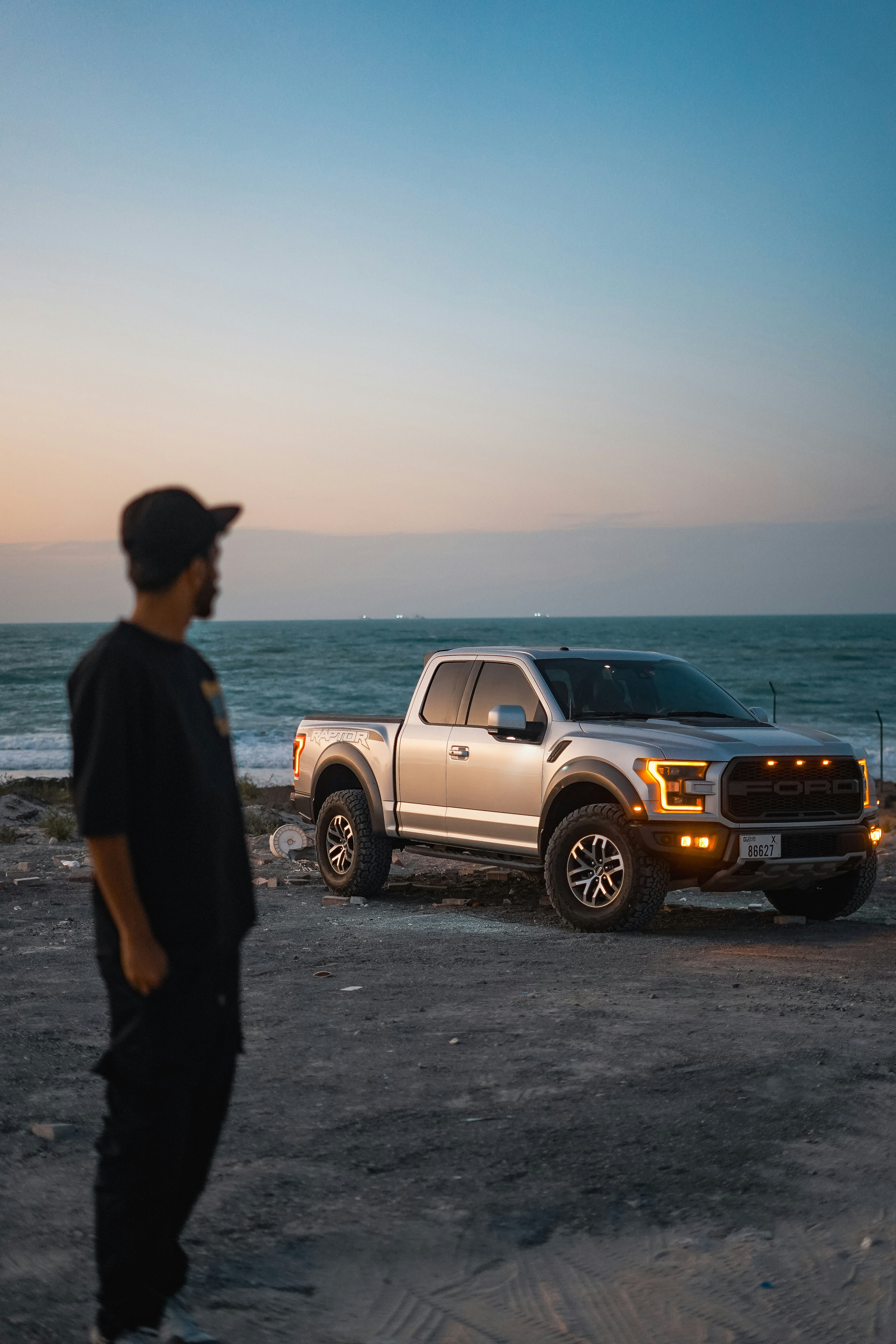 Um homem de pé ao lado de um caminhão, ligado, um, praia foto – Imagem ...