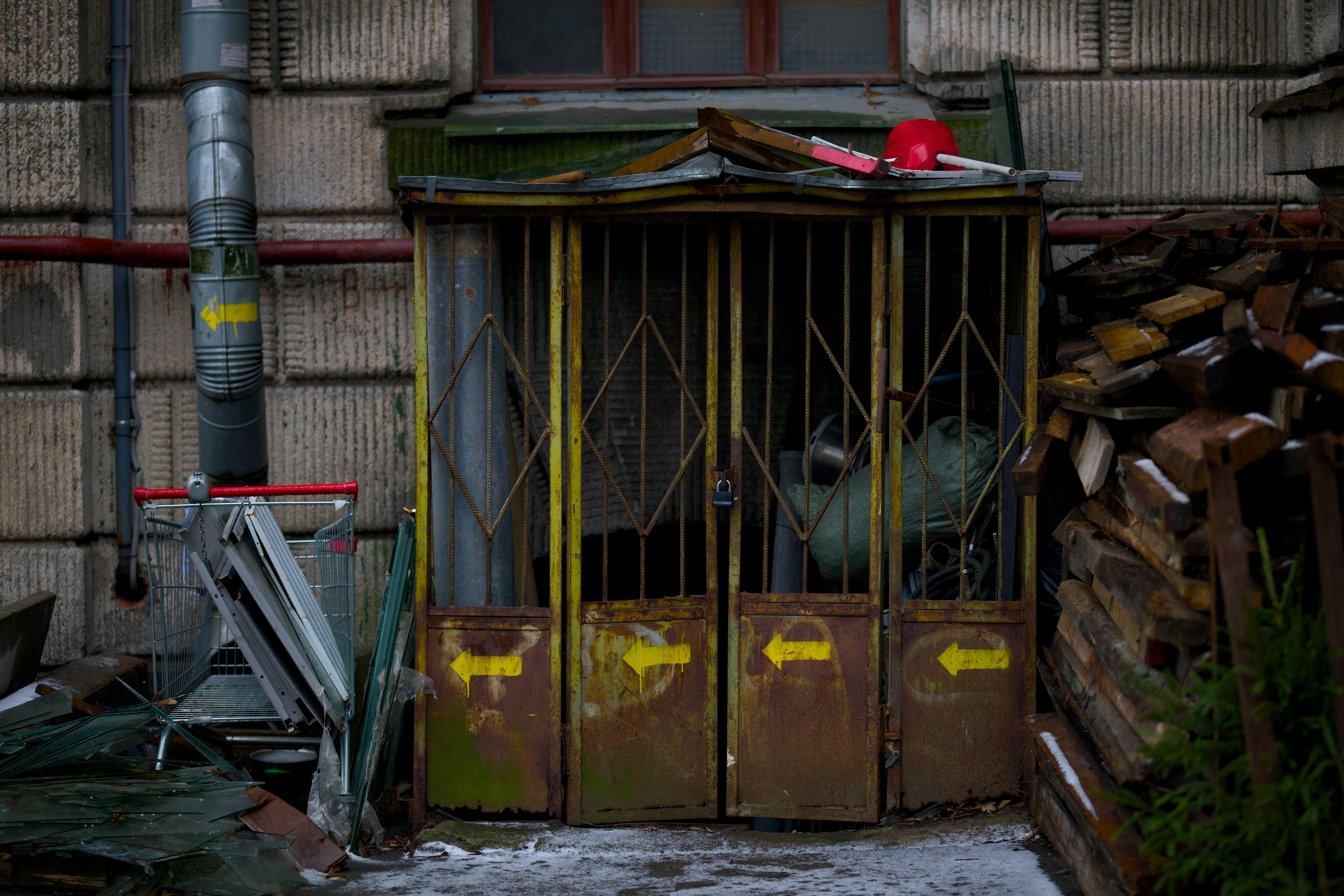 Yellow Arrows on a Rusted Gate: a Snow-Dusted Industrial Threshold