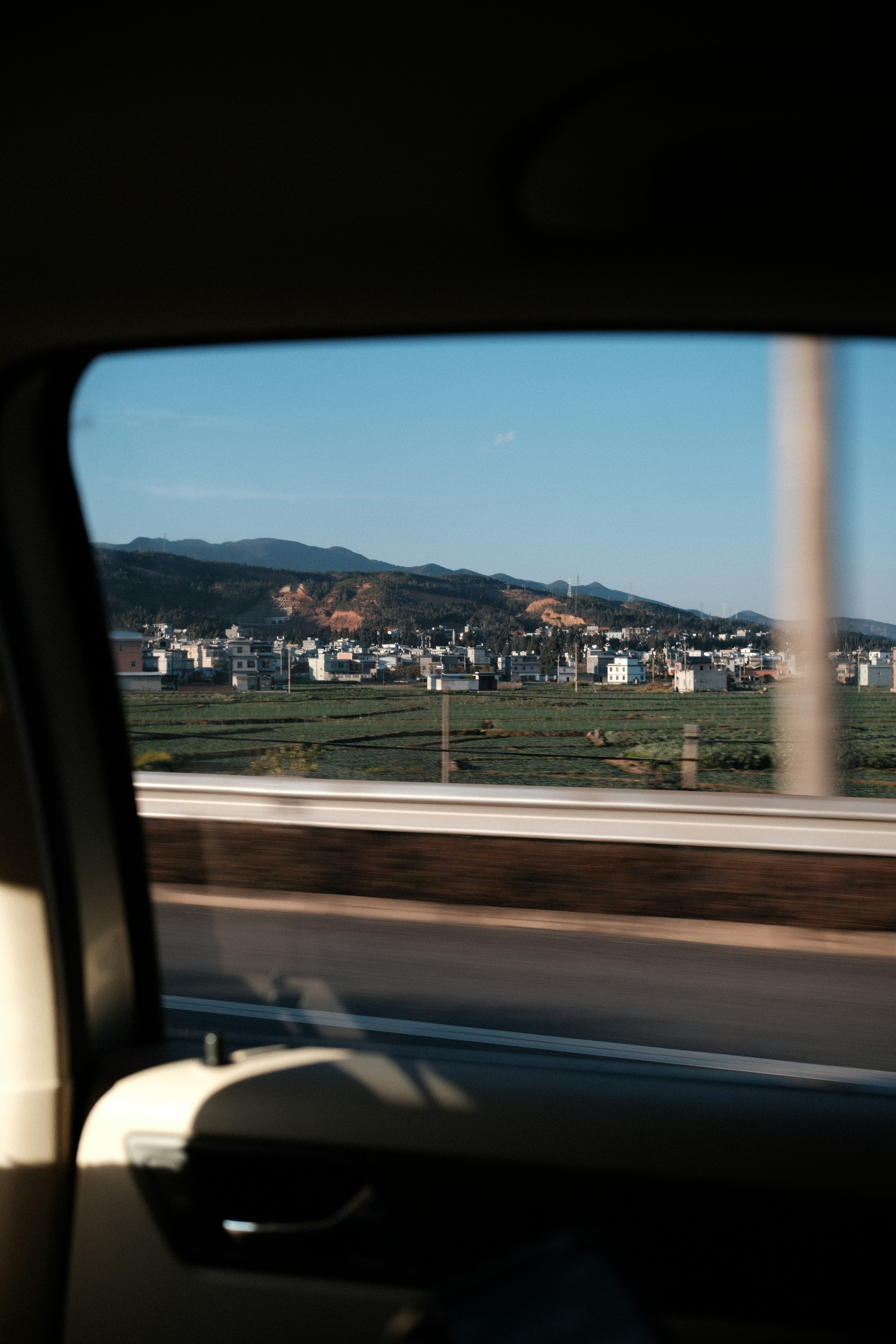 Horizon in Motion: Suburban Ridge Framed by a Car Window