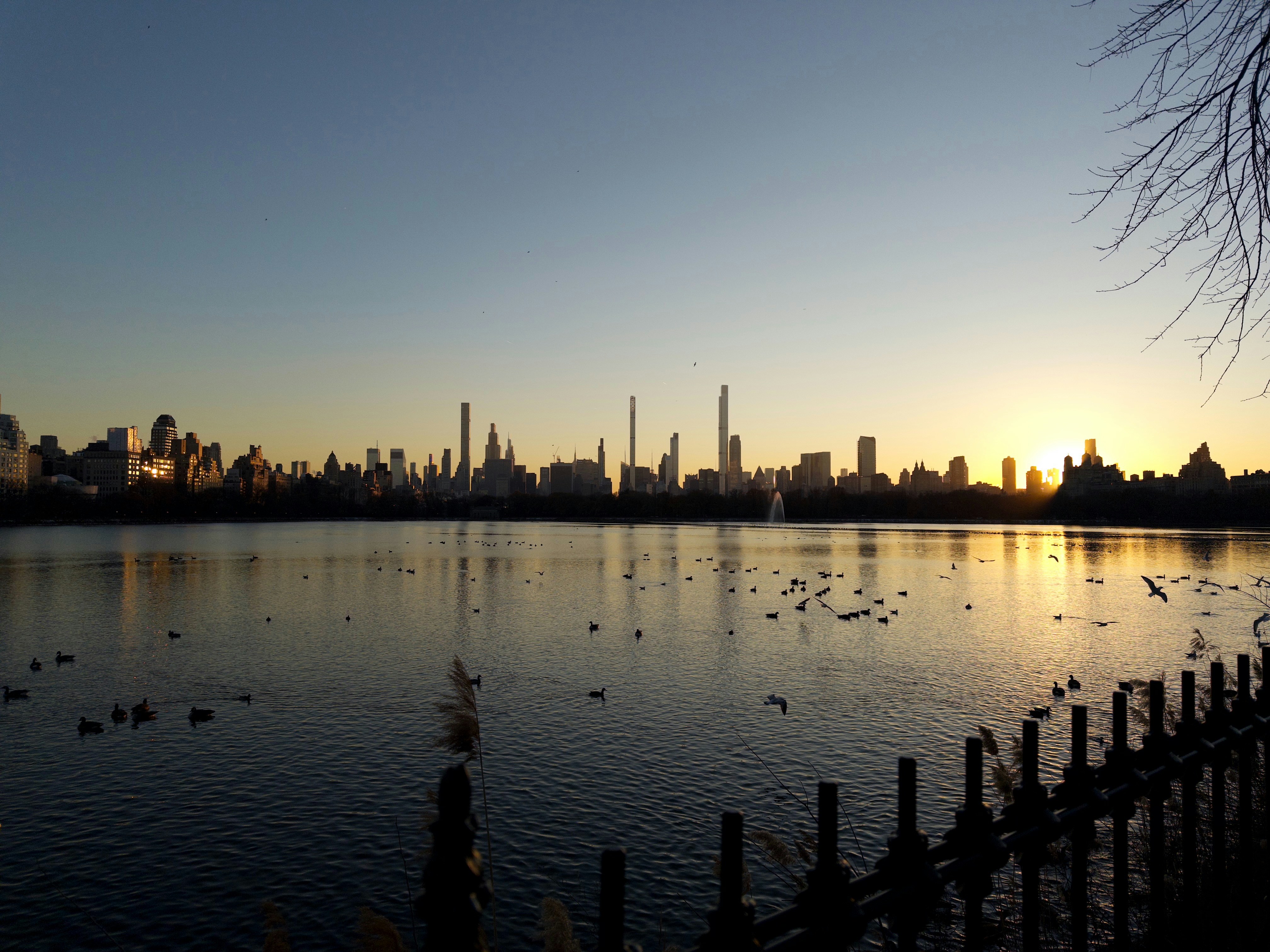 Golden Hour Skyline: Silhouettes Over a Quiet River