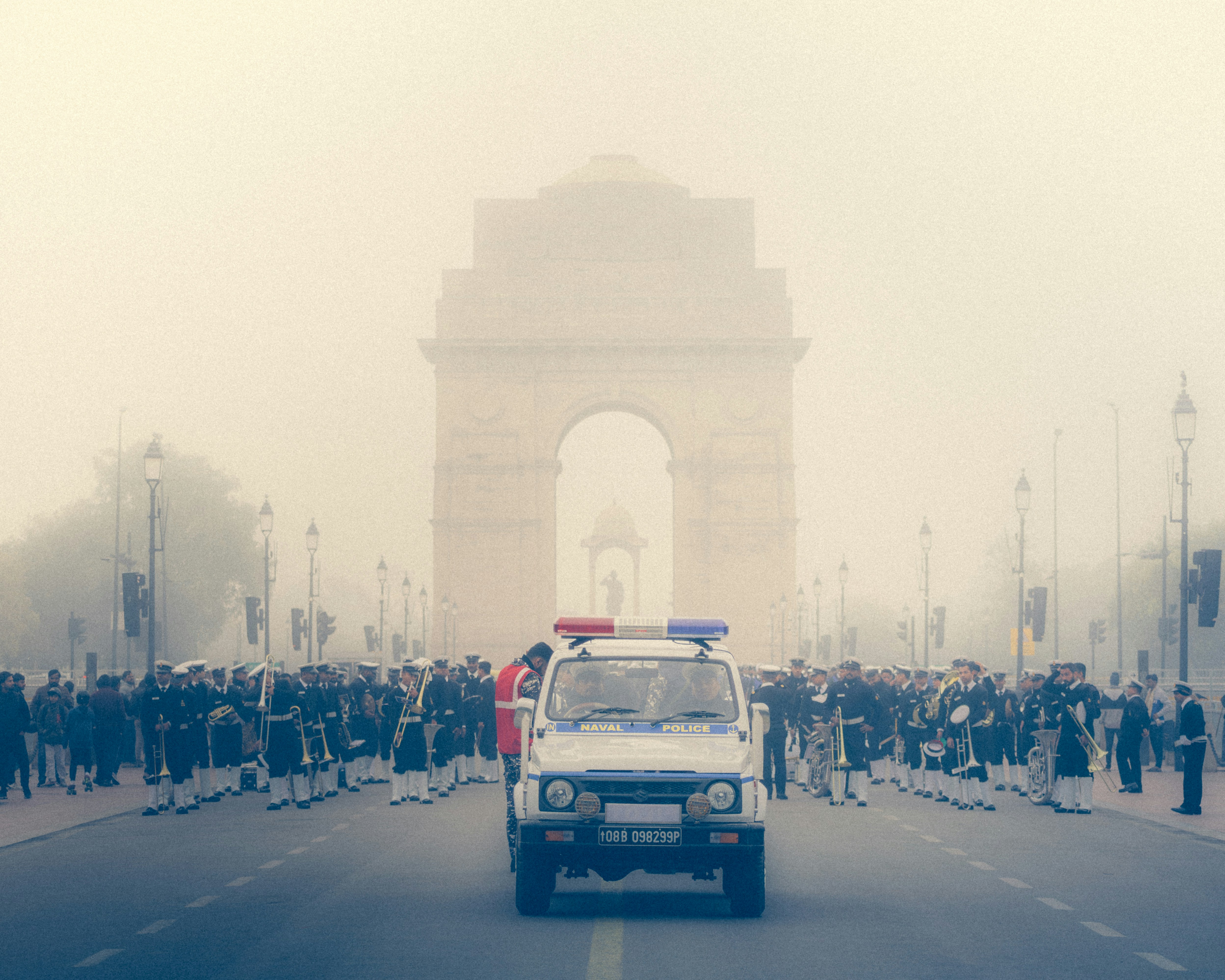 A police car driving down a street next to a crowd of people photo ...