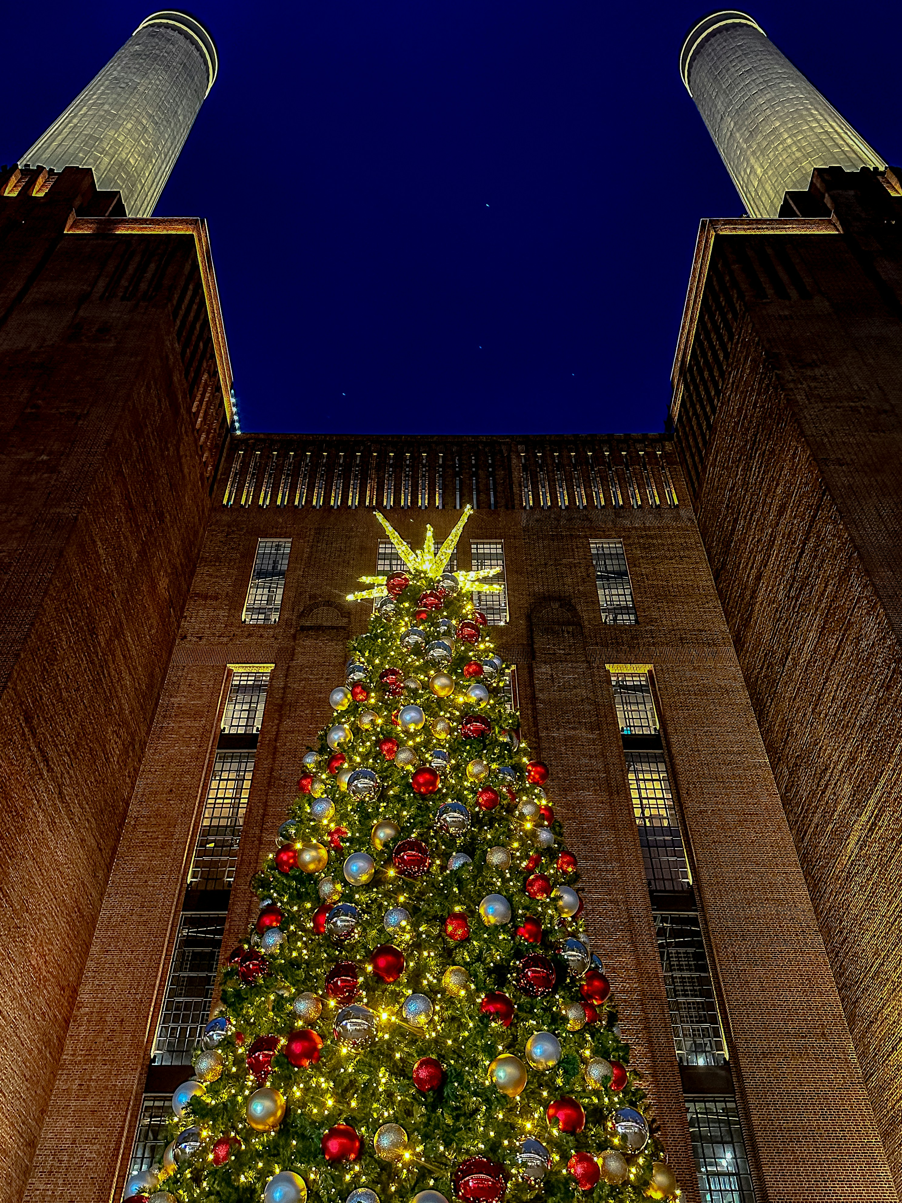 A large christmas tree in the middle of two tall buildings photo – Free ...