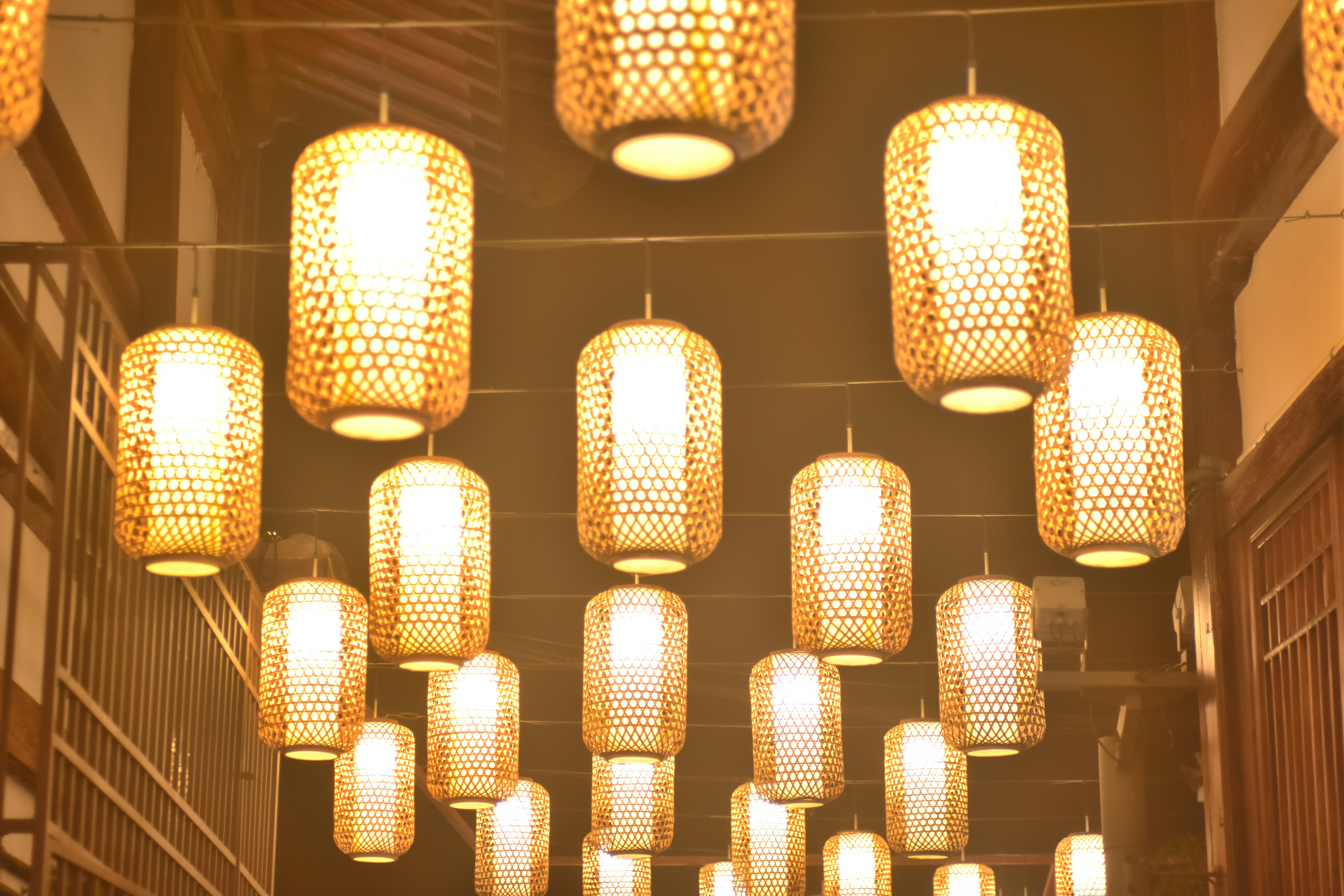 Warmly lit bamboo lanterns hanging in a cozy interior, creating an inviting atmosphere.