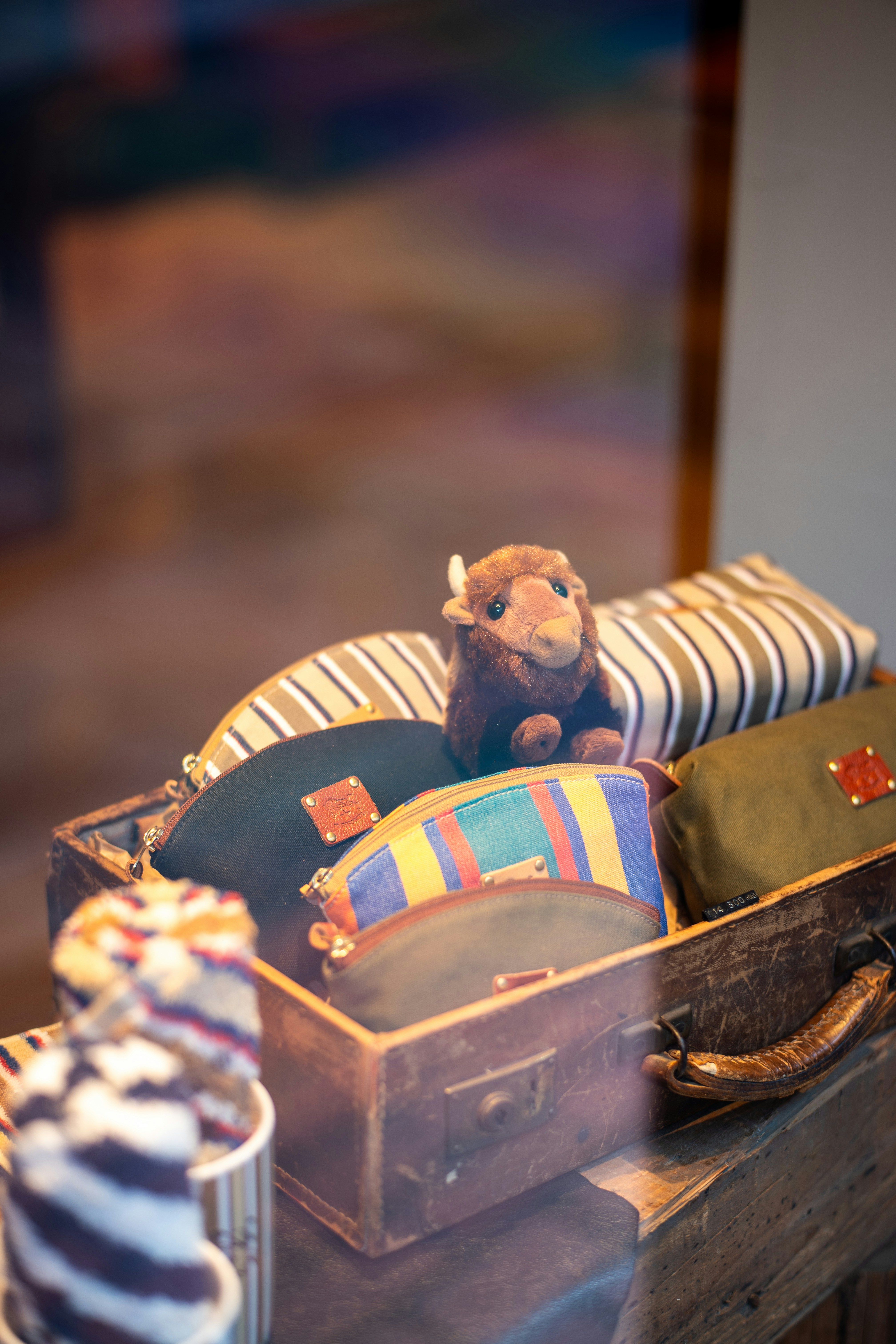 Merry Sentinel: Plush Monkey Over a Vintage Luggage Display