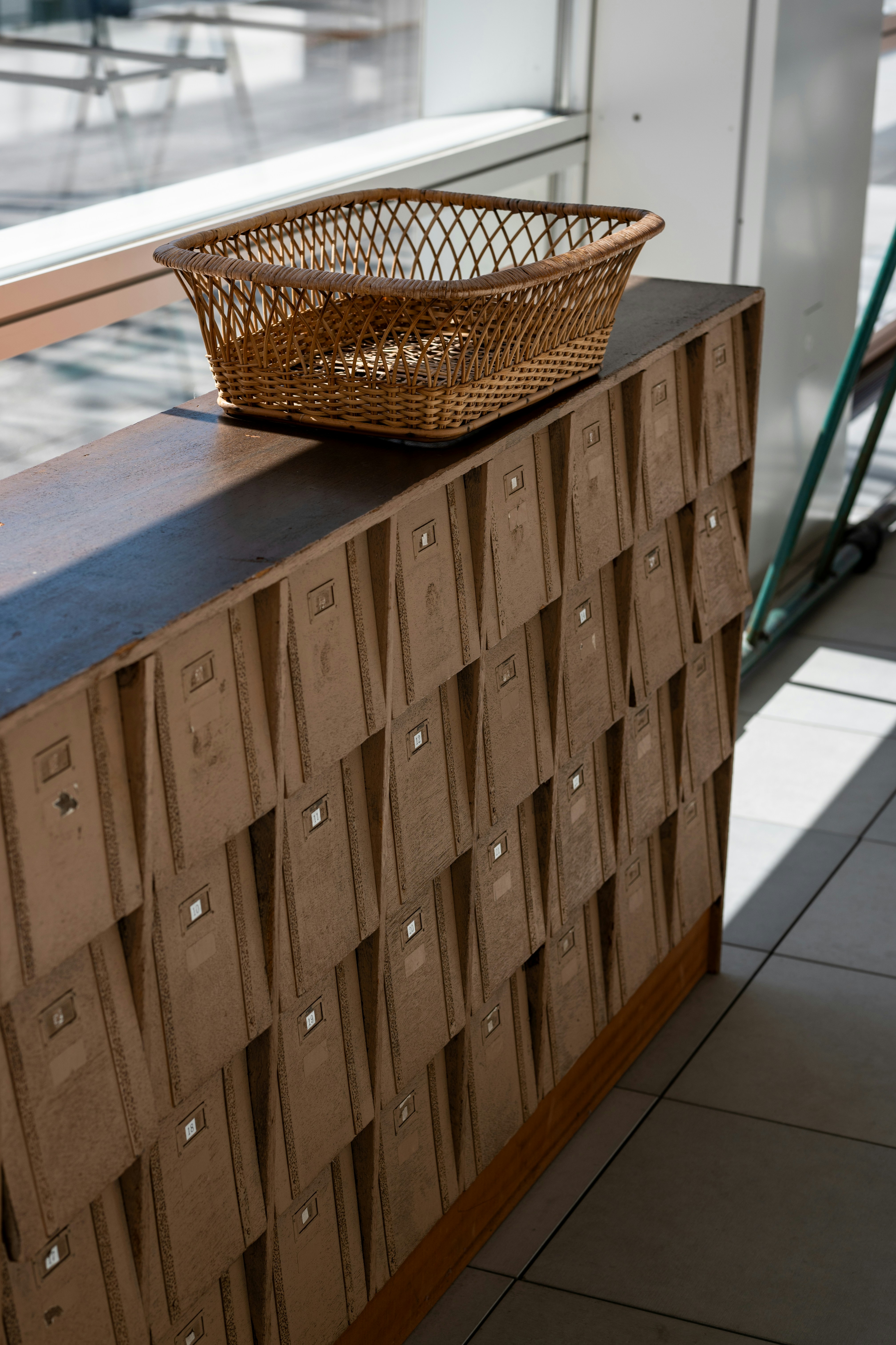 Sunlit Wicker Basket Perched Above a Row of Wooden Cubbies